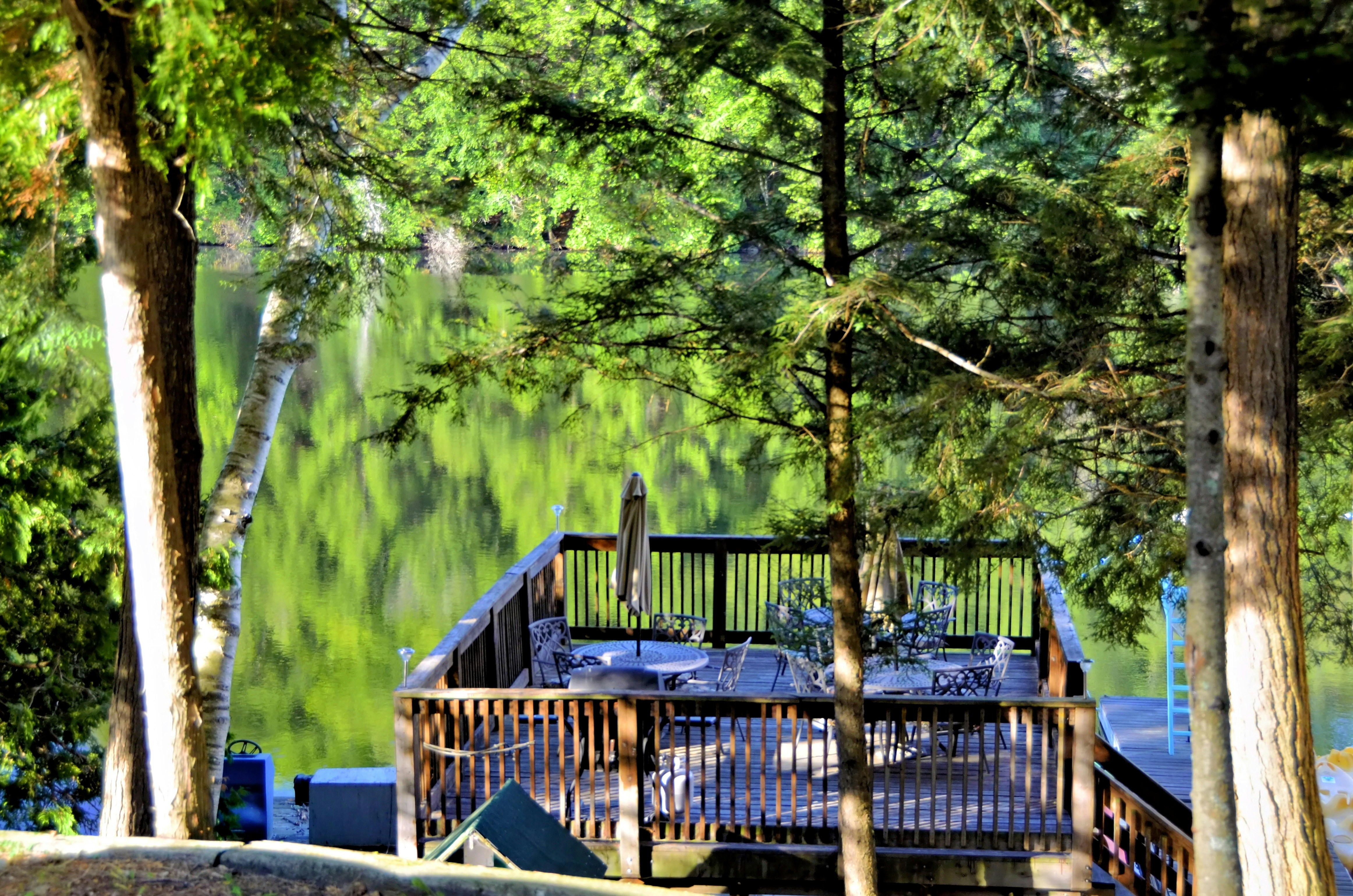 Wooden lakefront deck bathed in dappled light