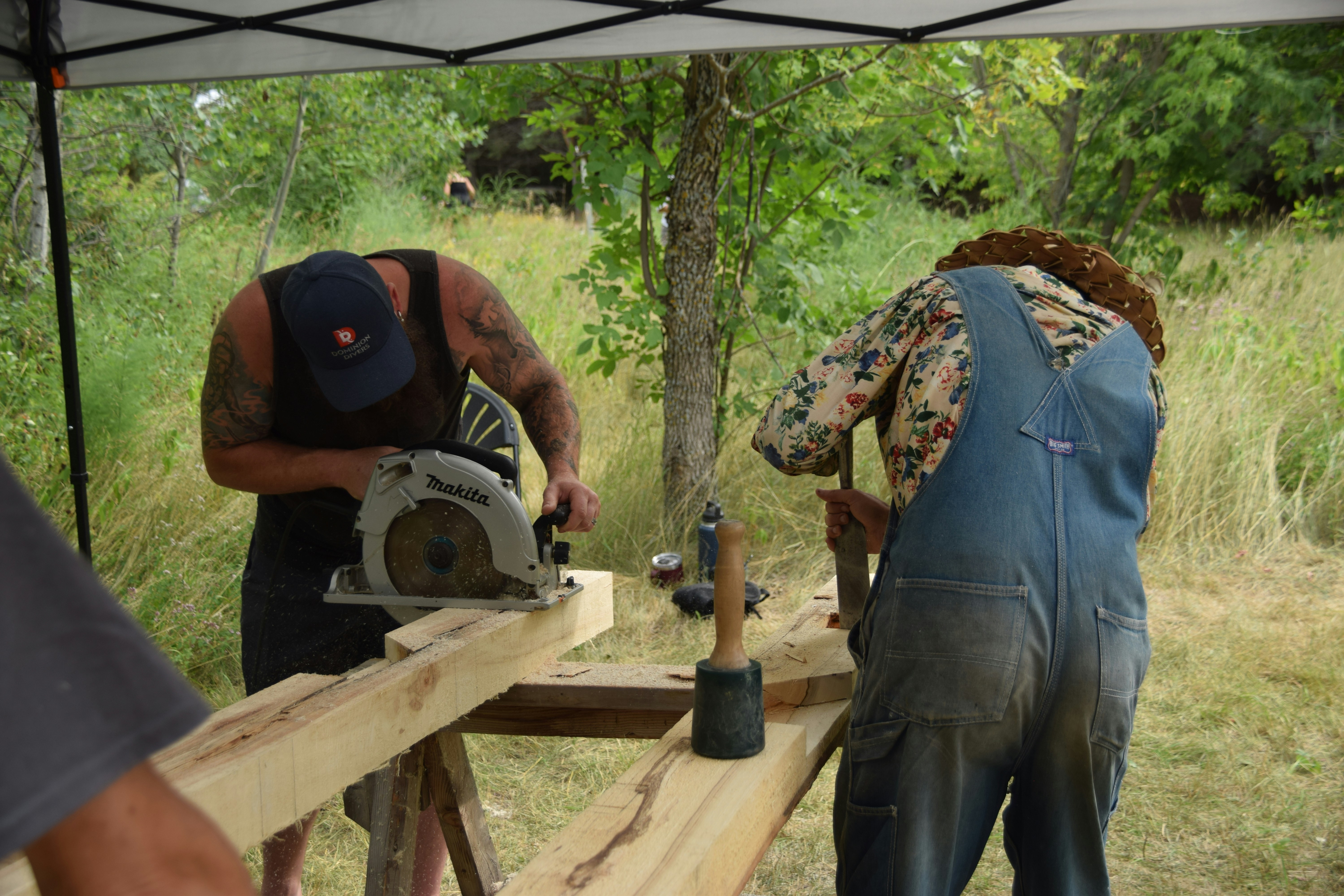 Woodworking in Focus: Two Craftsmen Under a Canopy