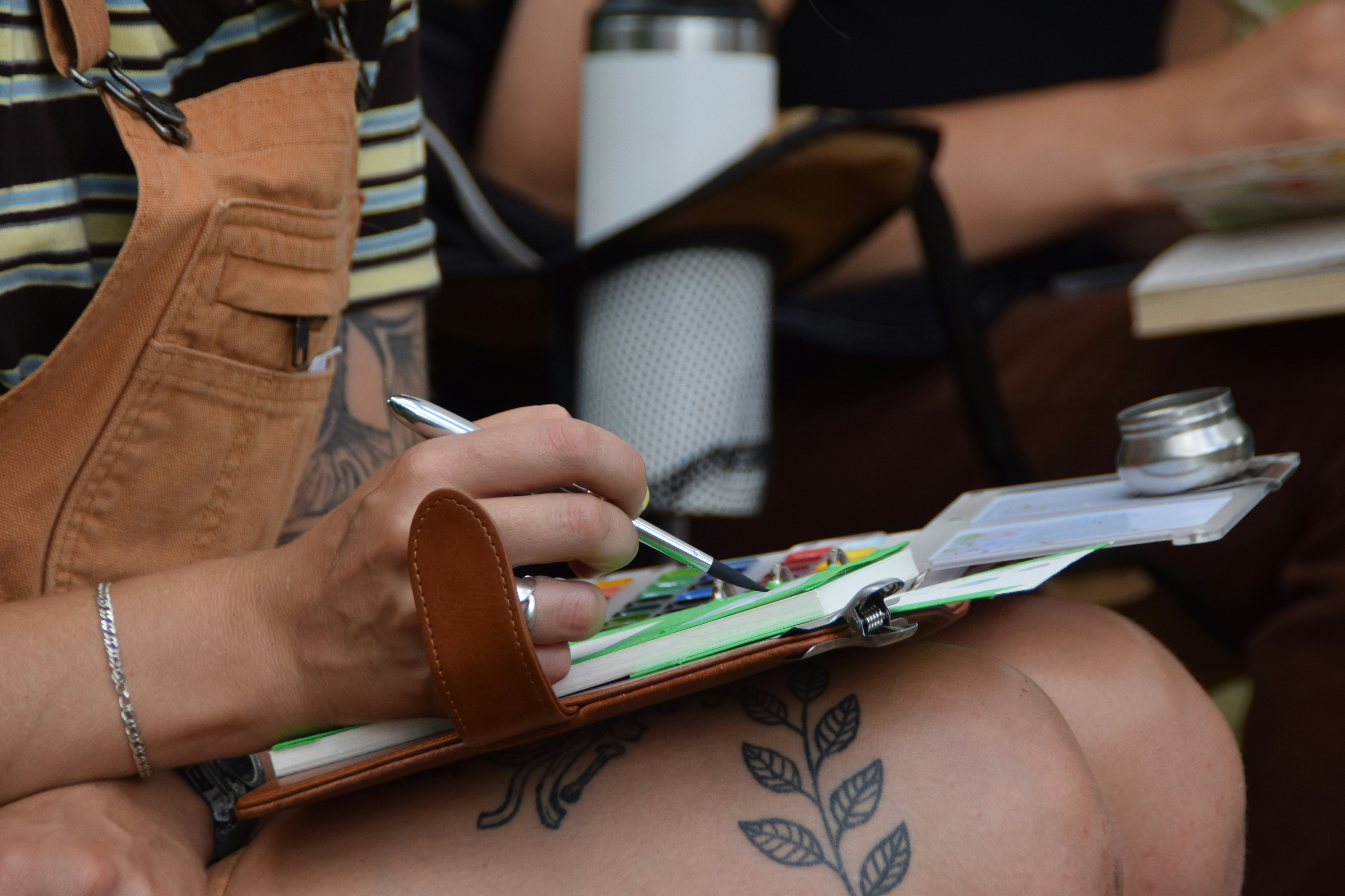 Inked Stillness: A Tattooed Hand Captures a Quiet Moment of Note-Taking