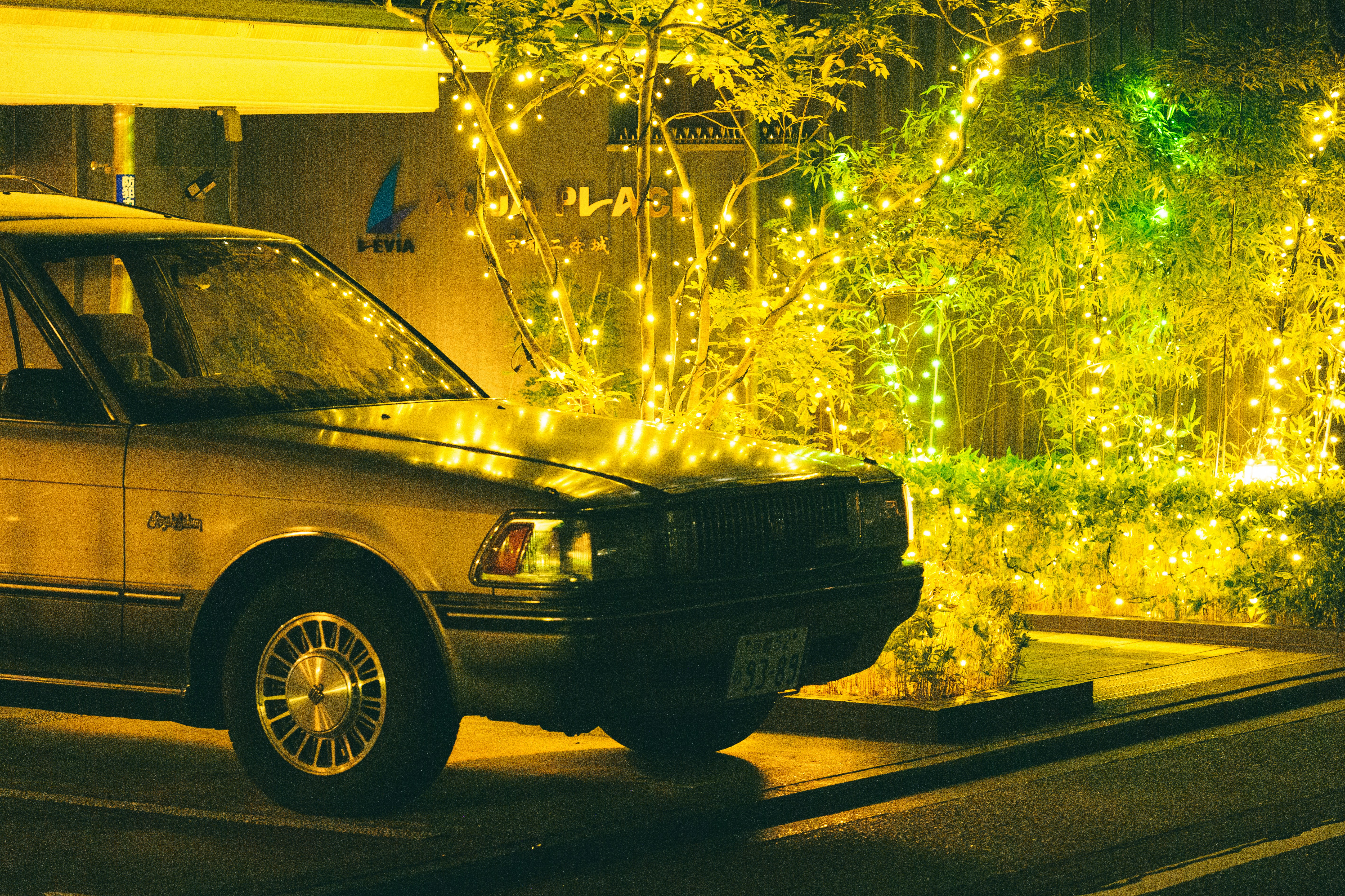 Golden Rides: A Neon-Warm Night by the Parked Sedan