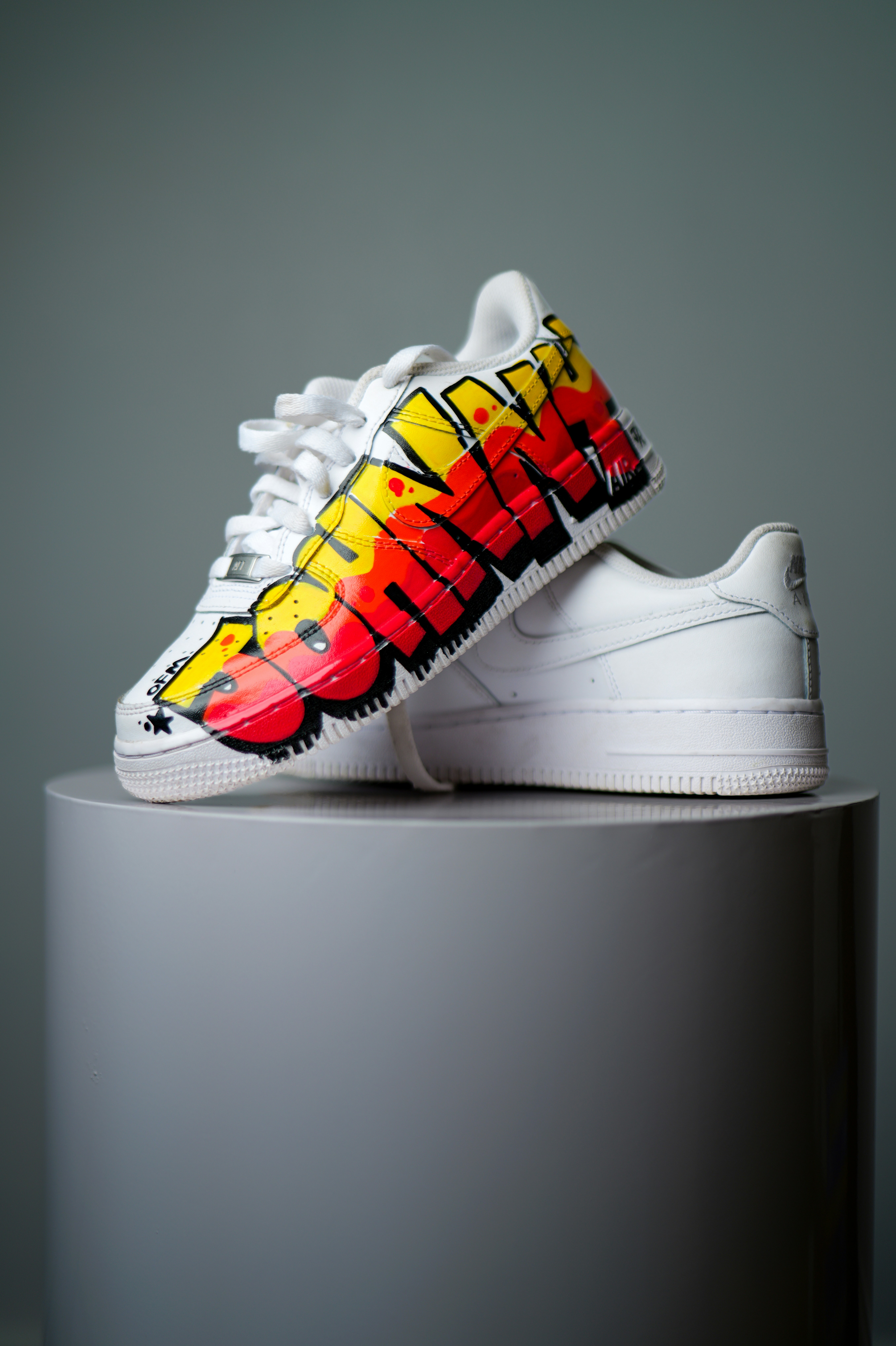Graffiti-splashed sneaker perched on a pedestal