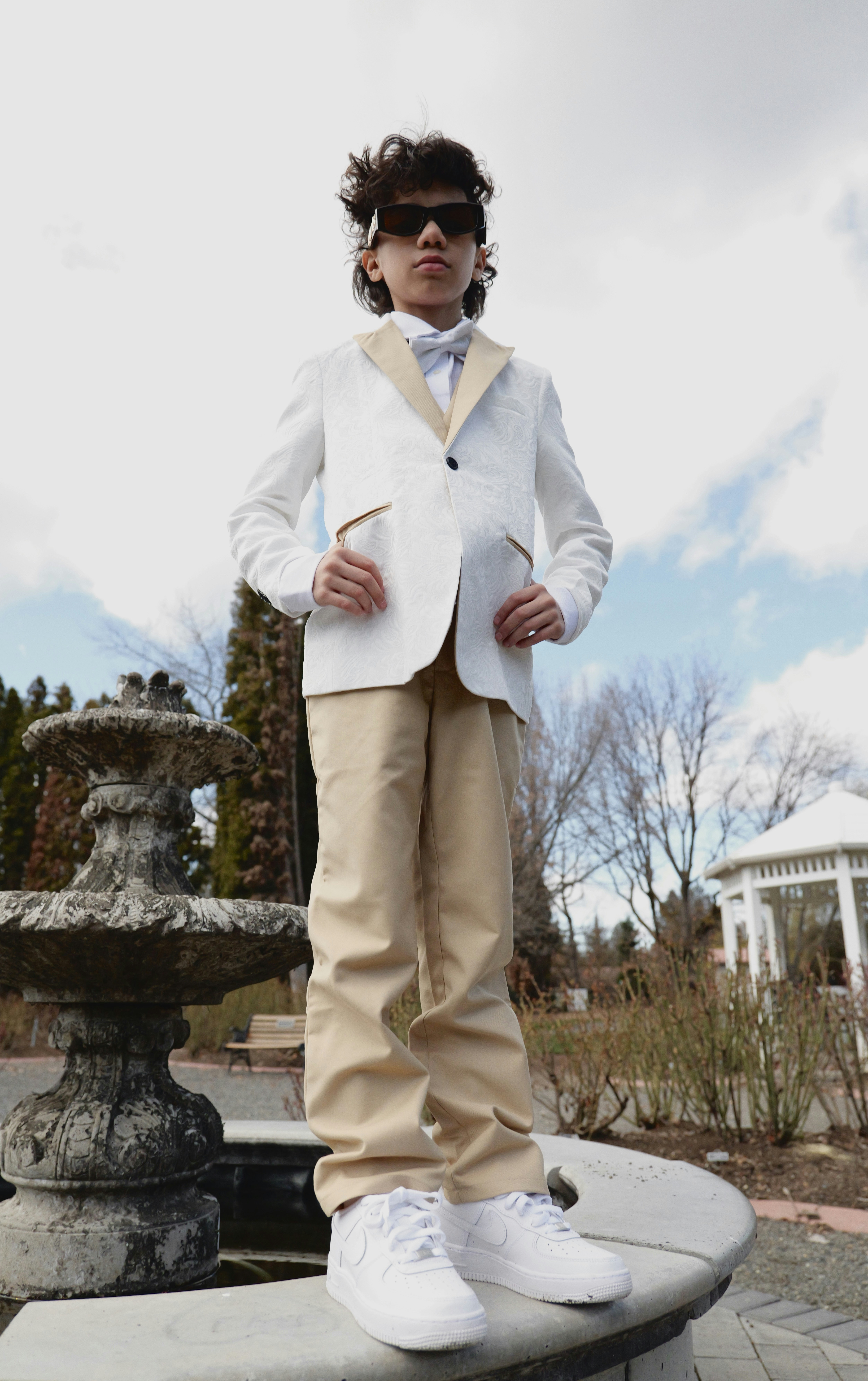 Youthful Stature in a Sunlit Courtyard: A Bold White Blazer Over khaki Trousers