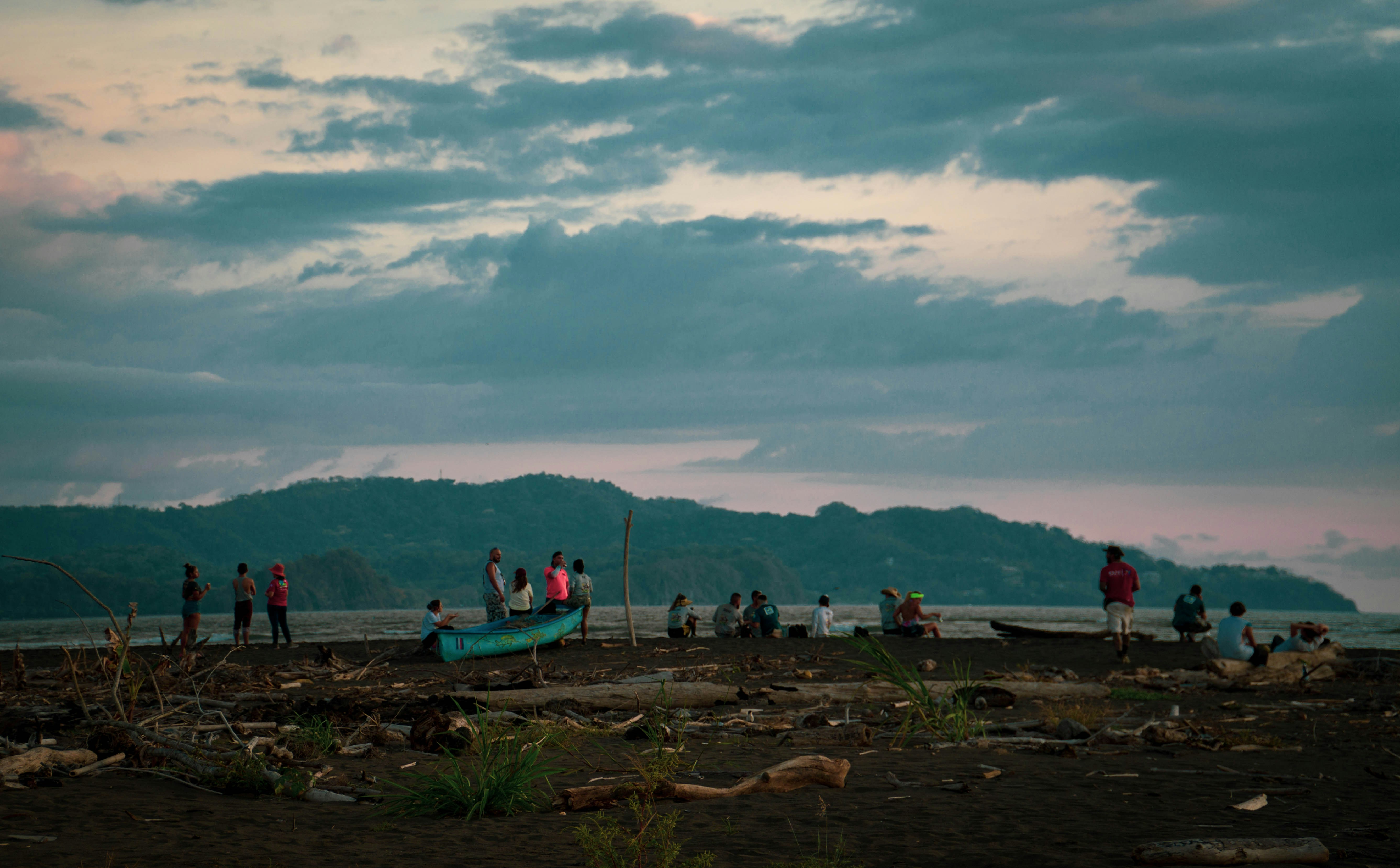 Distant figures on a windswept shoreline at dusk