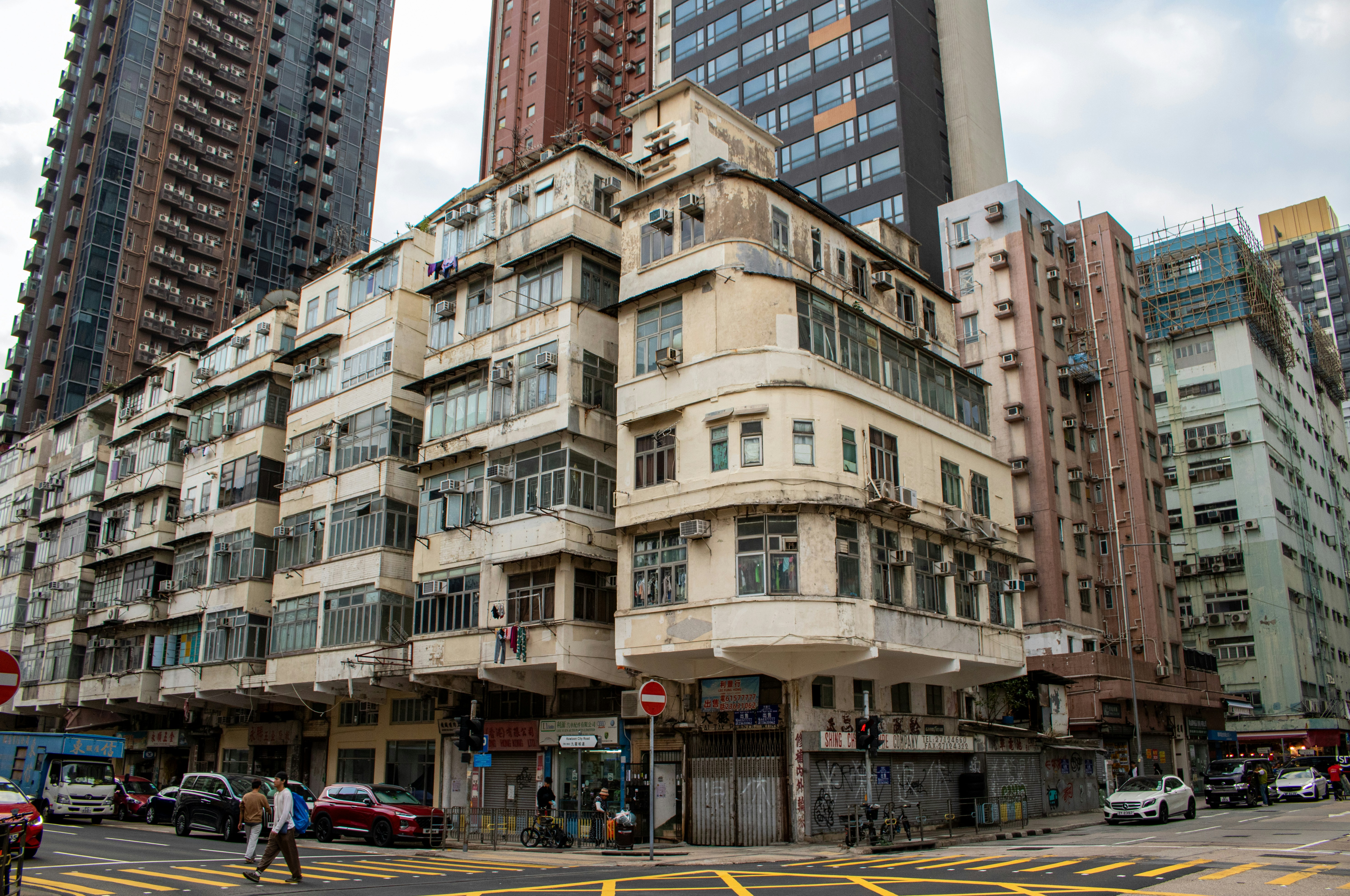 Urban Facade Convergence: A Weathered Corner Beneath Modern Skyscrapers