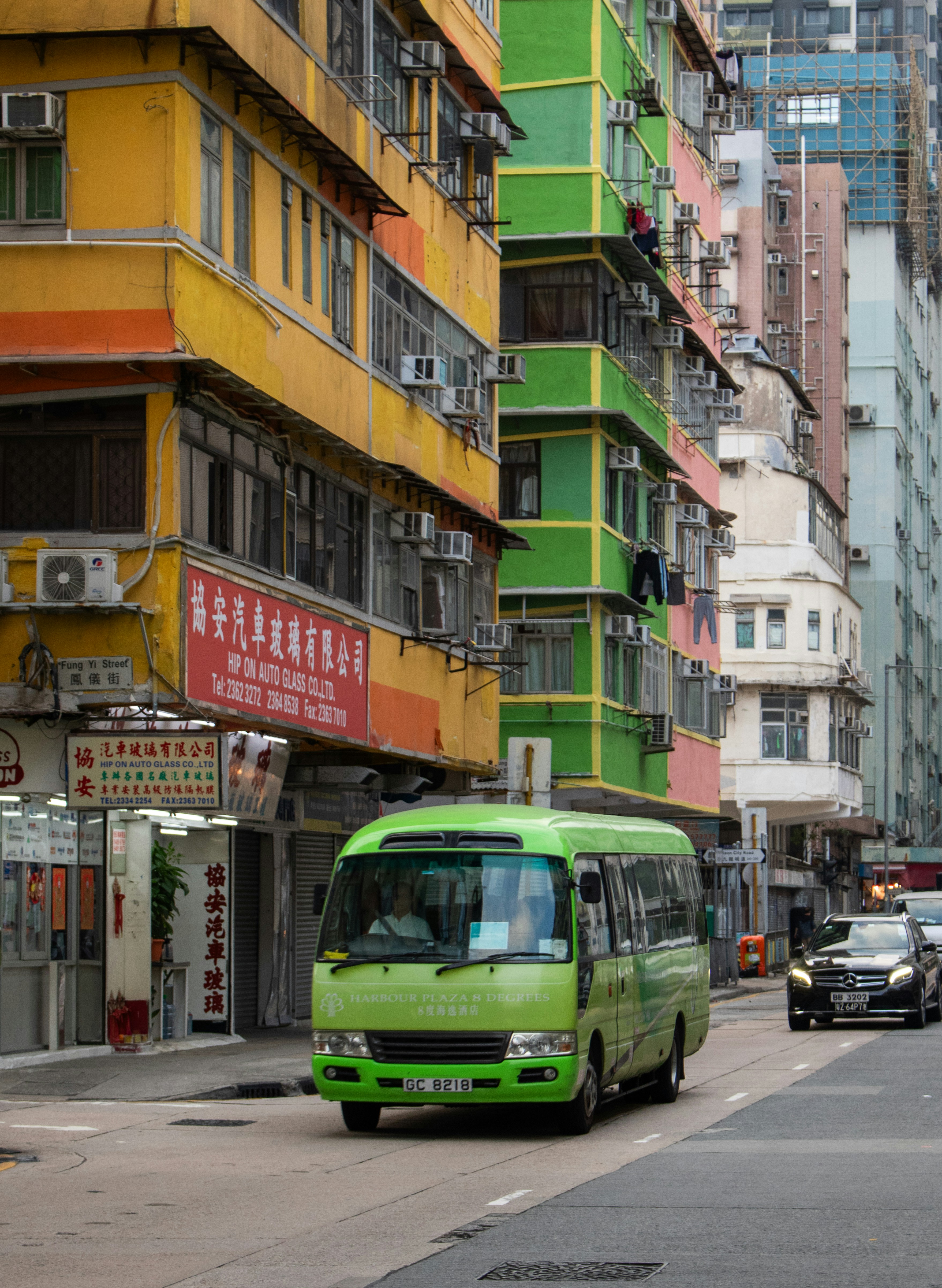 Vibrant Urban Corridor: A Lime Bus Navigates a Colorful Downtown Street