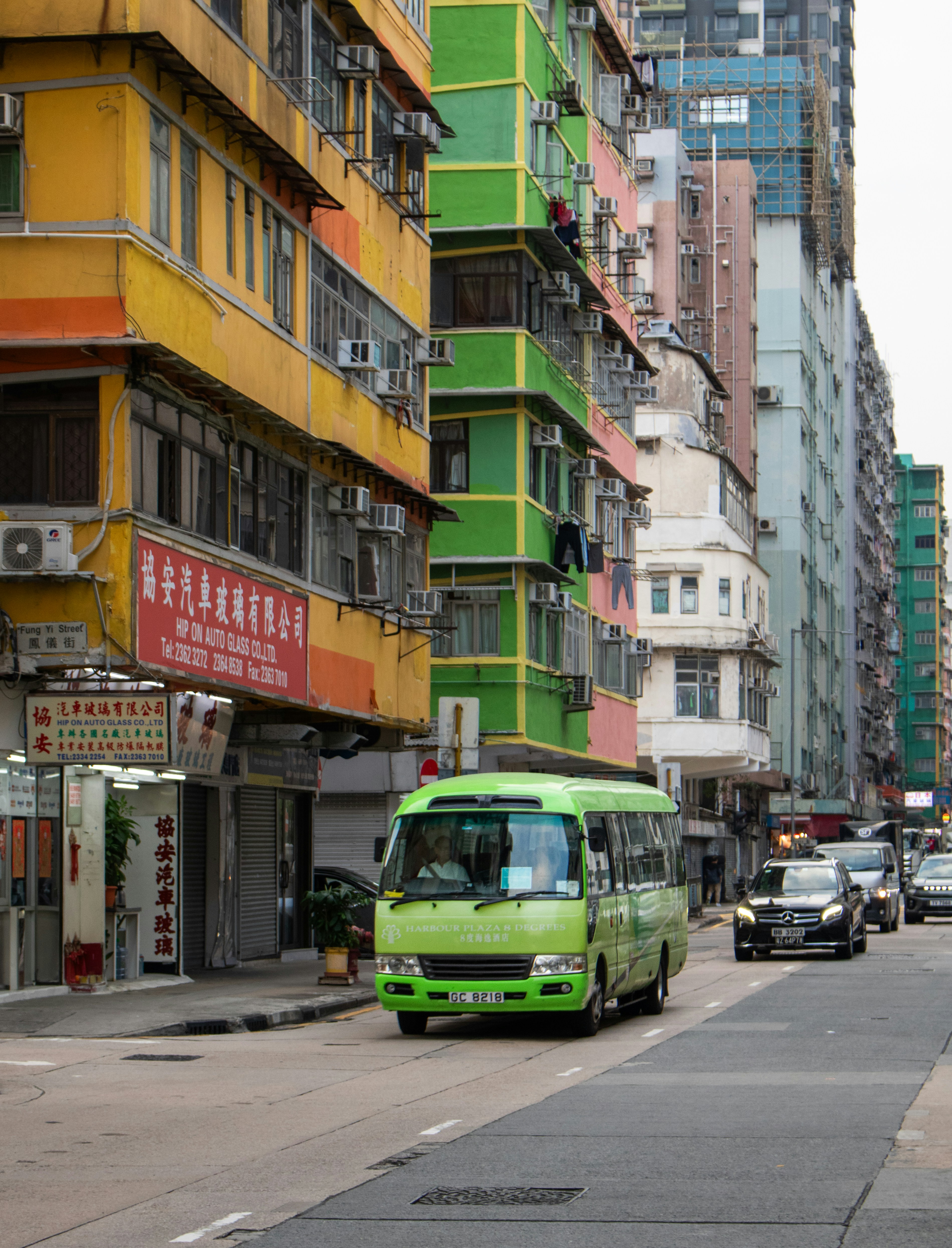 Emerald Bus Amid a Colorful City Cliff
