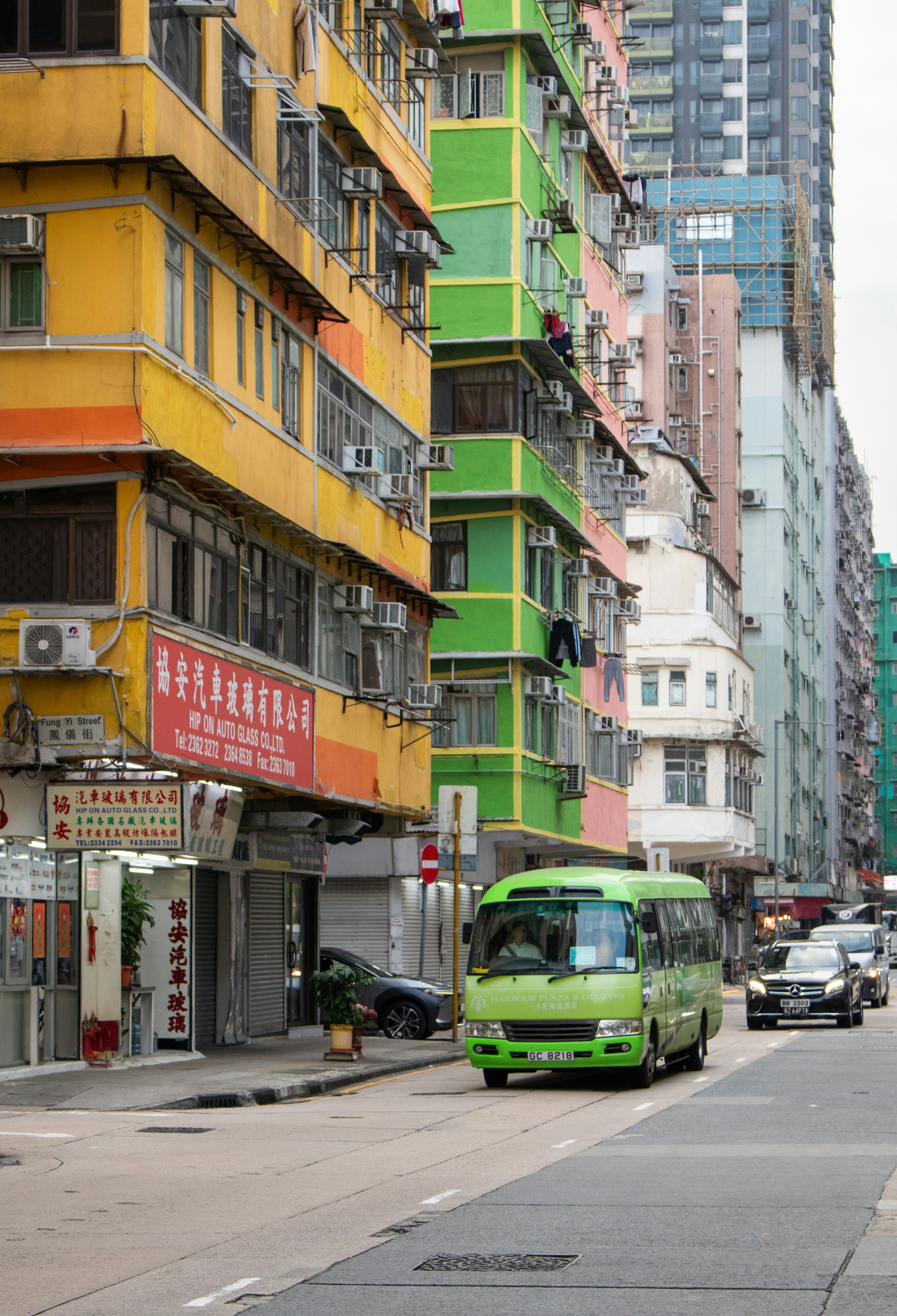 Chromatic Corridor: A Bright Green Bus Traverses a Colorful Urban Palette