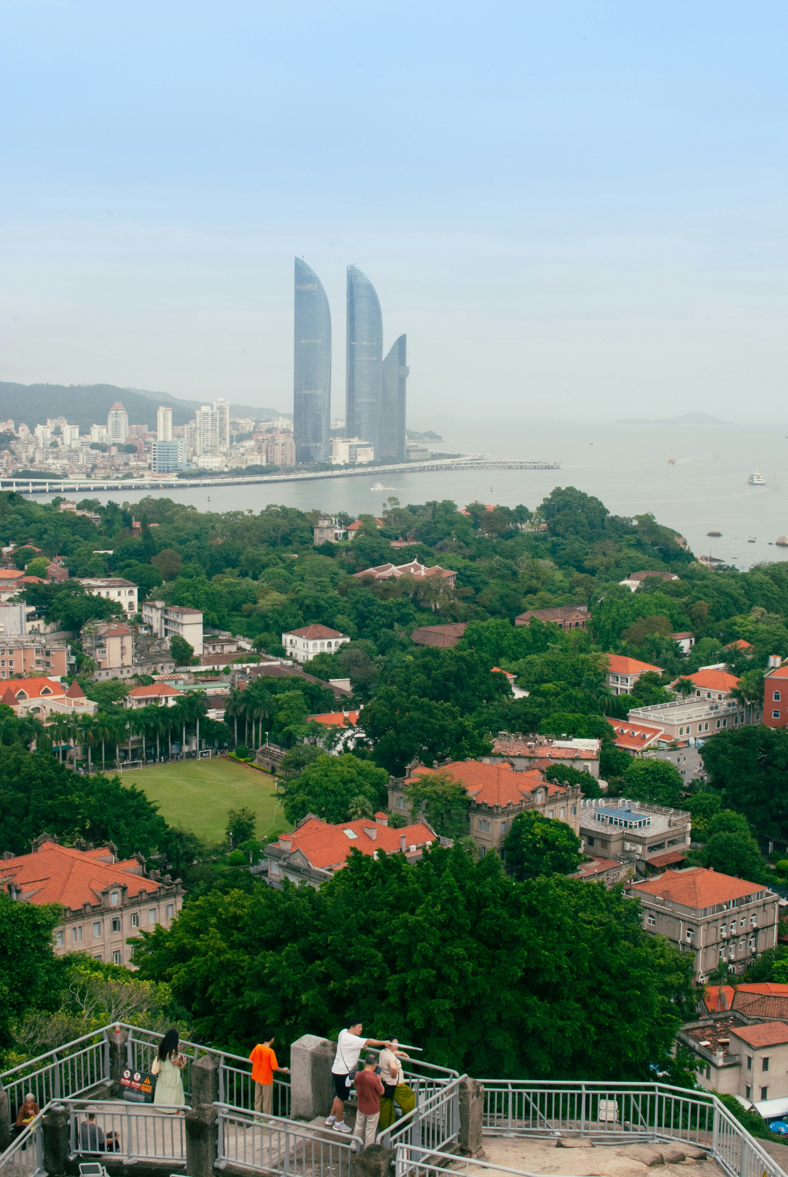 A Coastal Cityscape: Modern twin towers rising above a leafy hillside