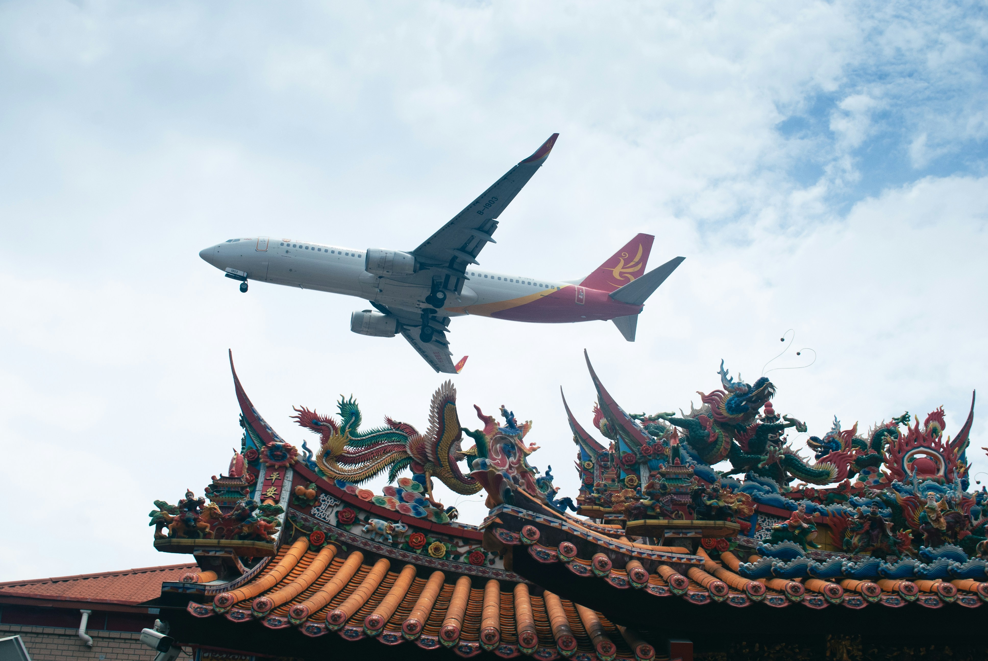 Jet Above the Dragon Roof: A Moment of Flight Over Traditional Temples