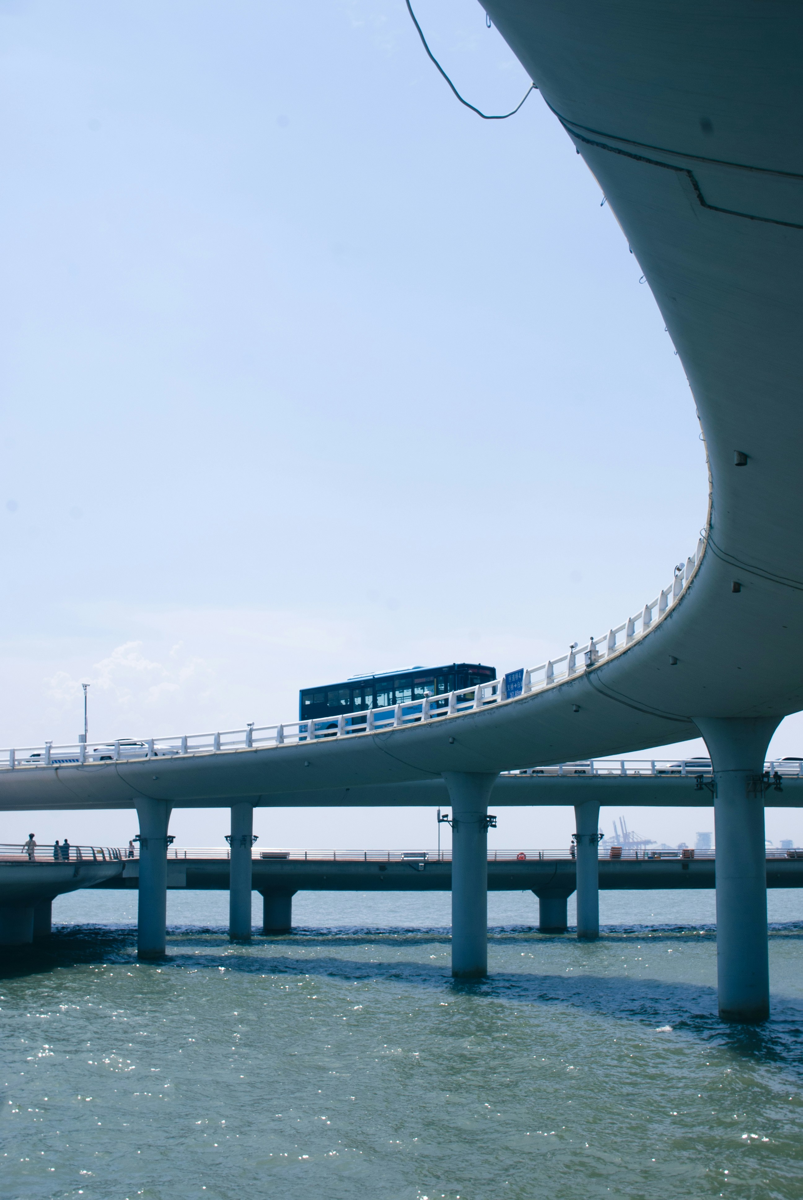 Curved transit over turquoise waters: a coastal highway arches into the horizon