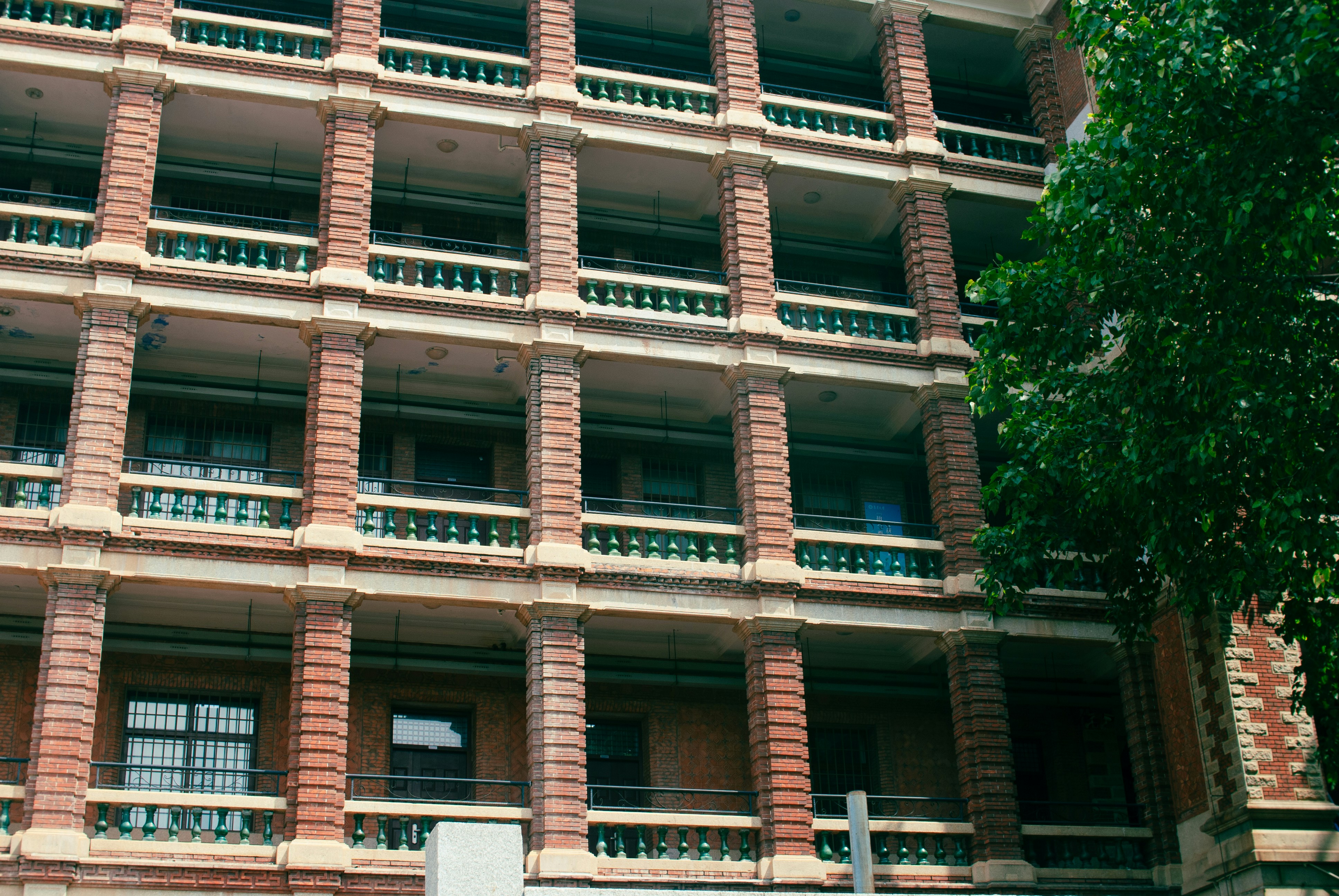 Brick-and-Balconied Facade: Repeating Geometry in a Sunlit Courtyard