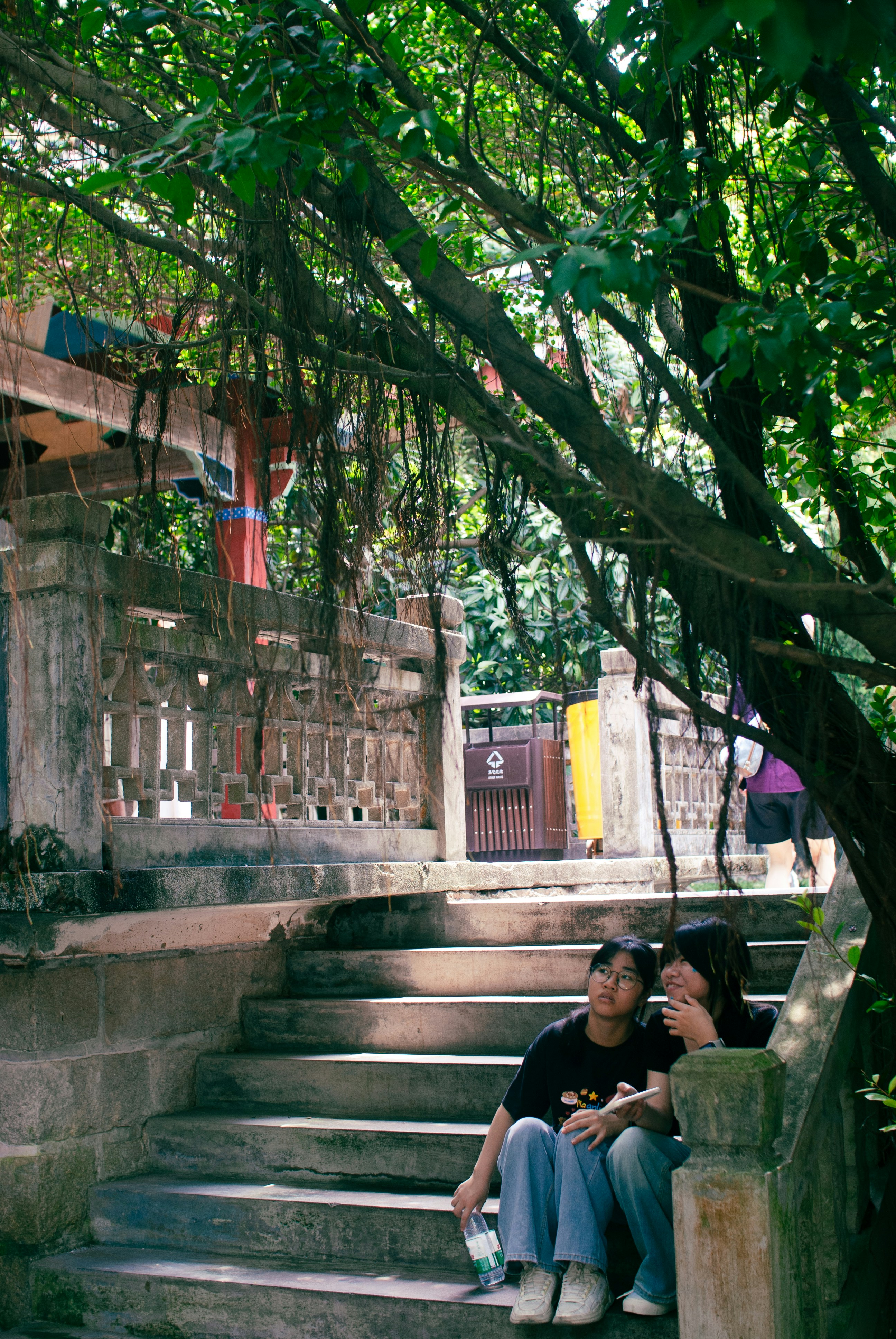 Quiet Moment on the Steps: Friends Resting in a Lush Corridor