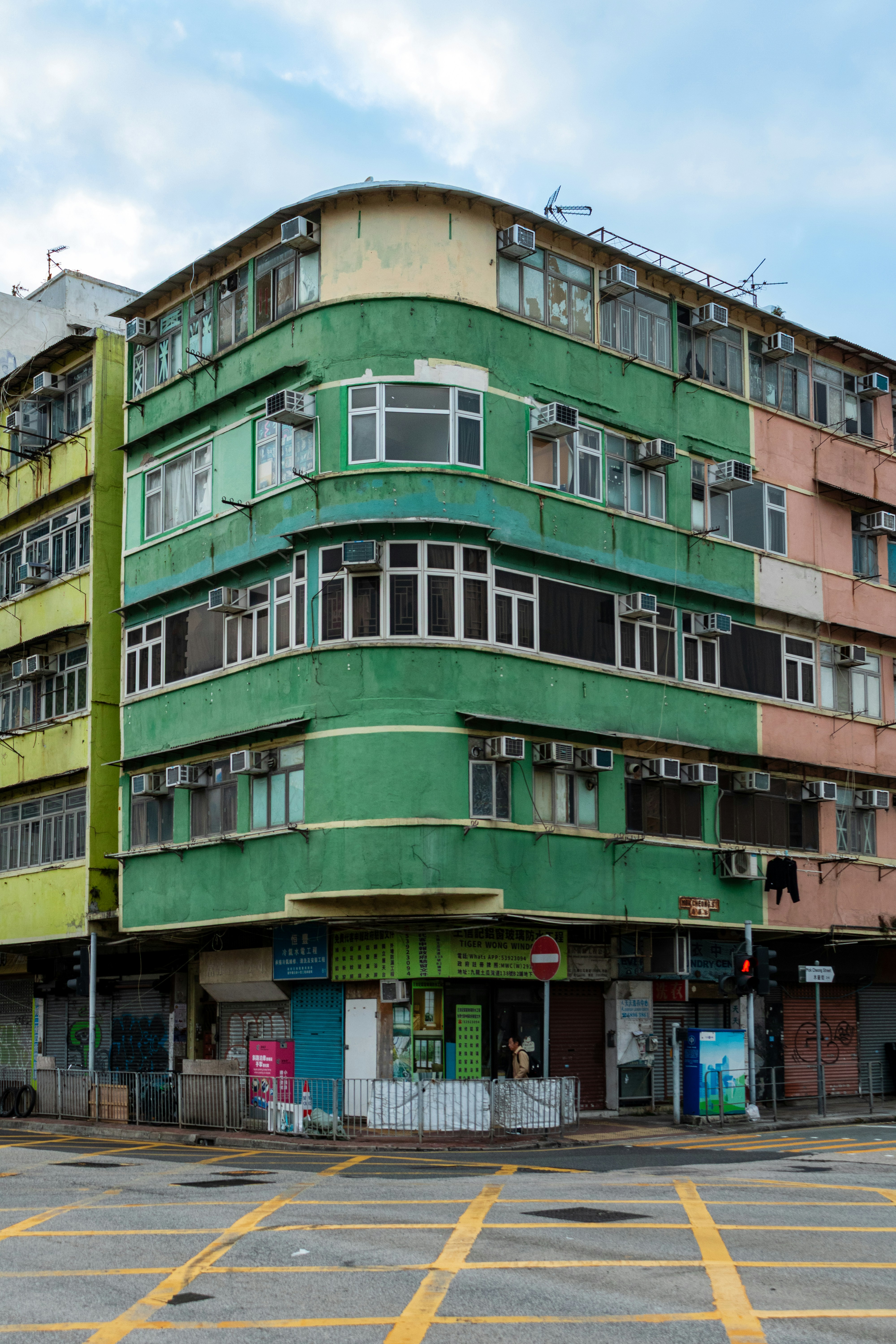 Curved Green Facade: A Cornered Building with Timeworn Charm