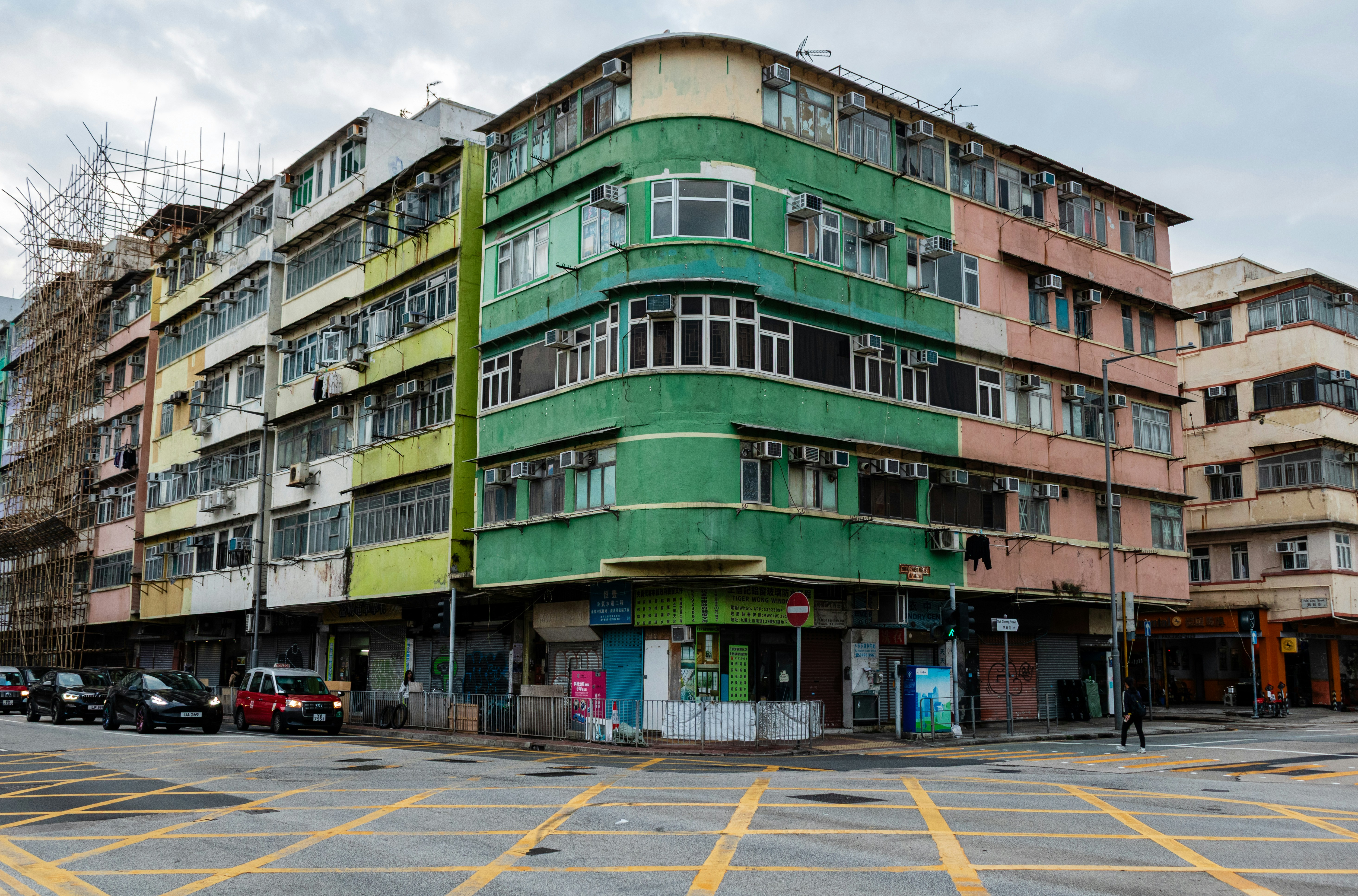 Corner Green: A Multicolored Apartment Block Framing the Busy Street
