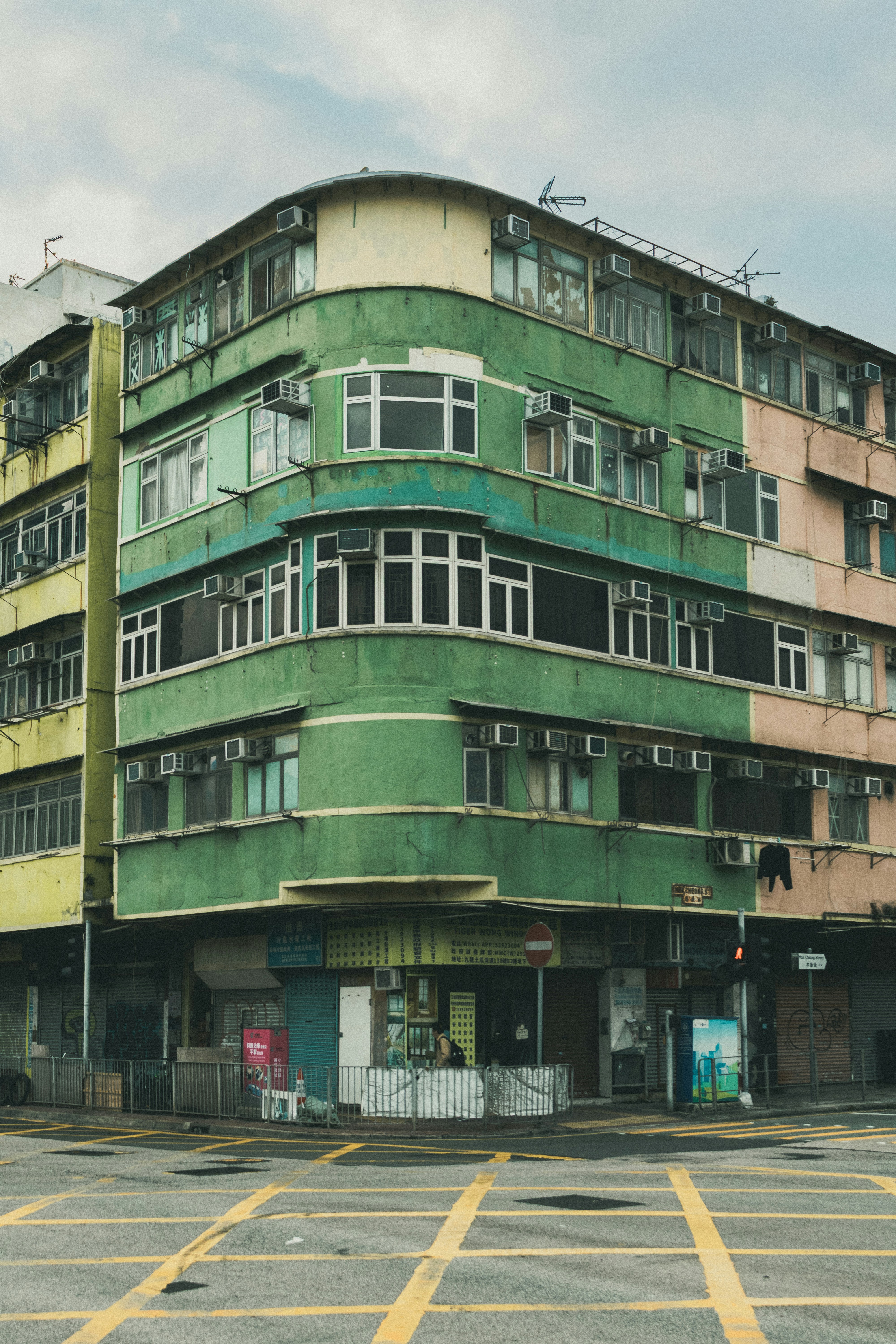 Colorwashed Corner: A Waiting Facade on a Green-Striped Block