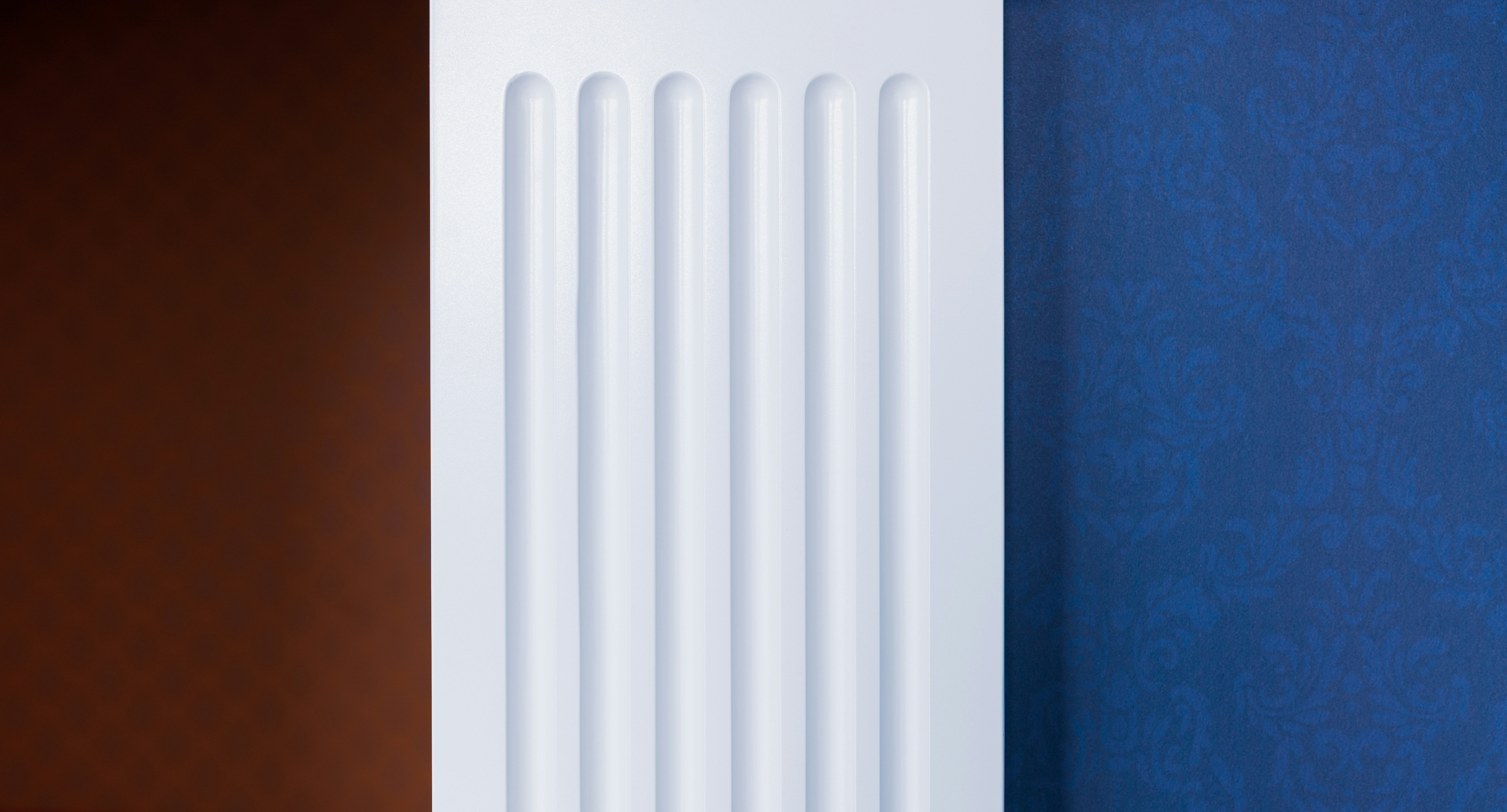 Minimal abstract composition featuring vertical white ridges flanked by brown and blue color blocks, emphasizing geometric contrast and texture.