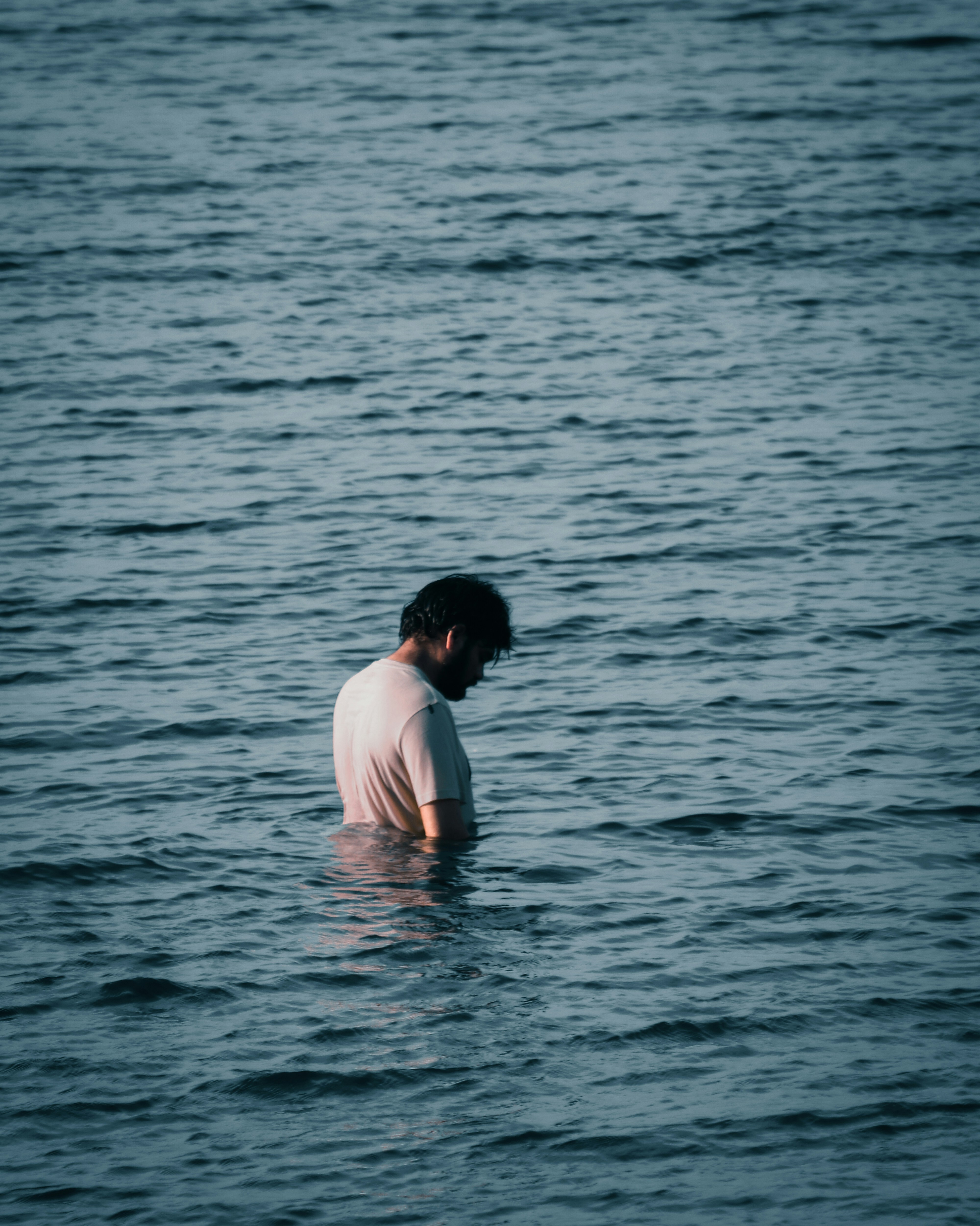 Mid-Water Reverie: A Shrouded Figure in Quiet Seas