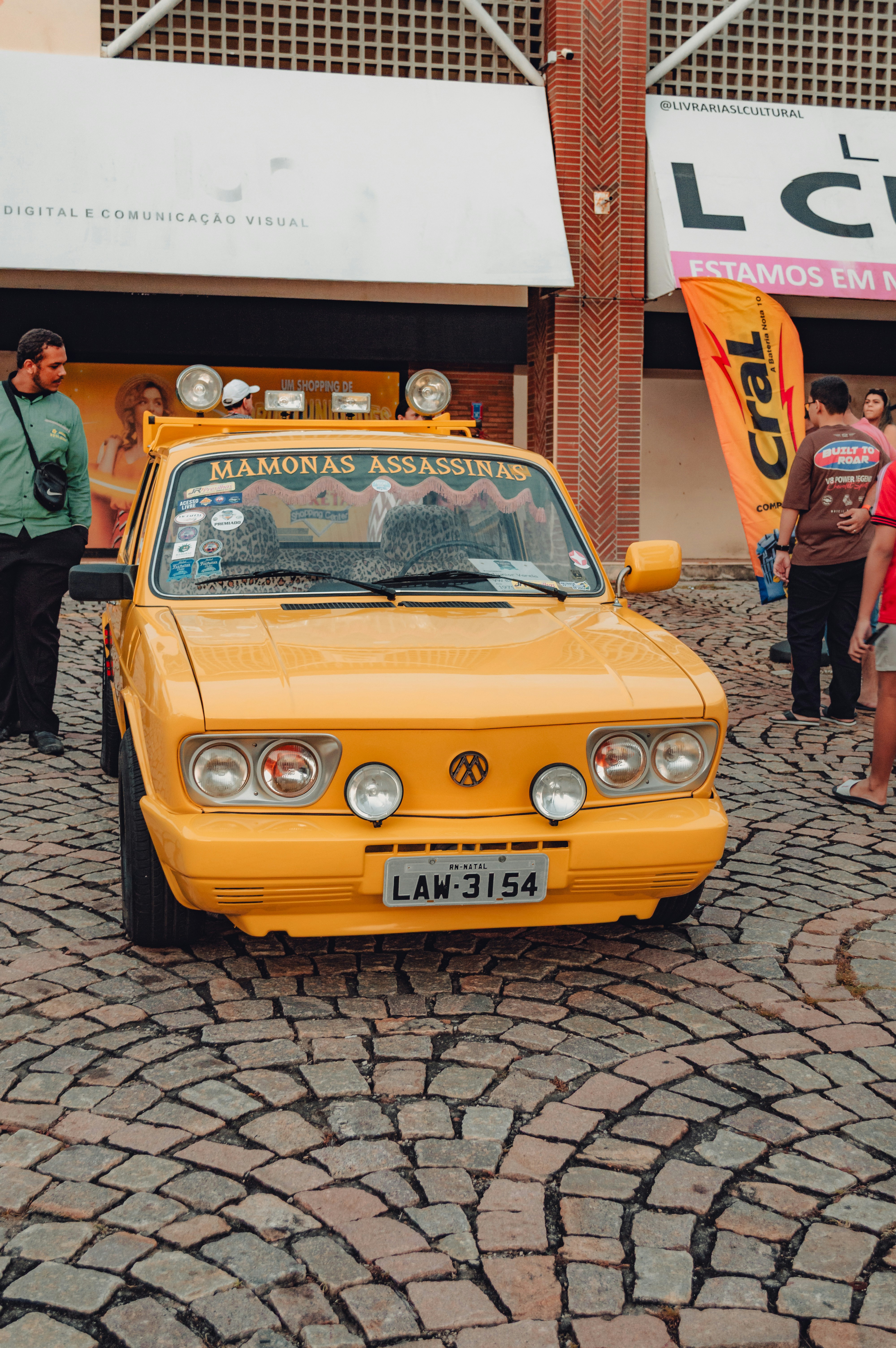 Sunlit yellow vintage pickup on cobblestone stage