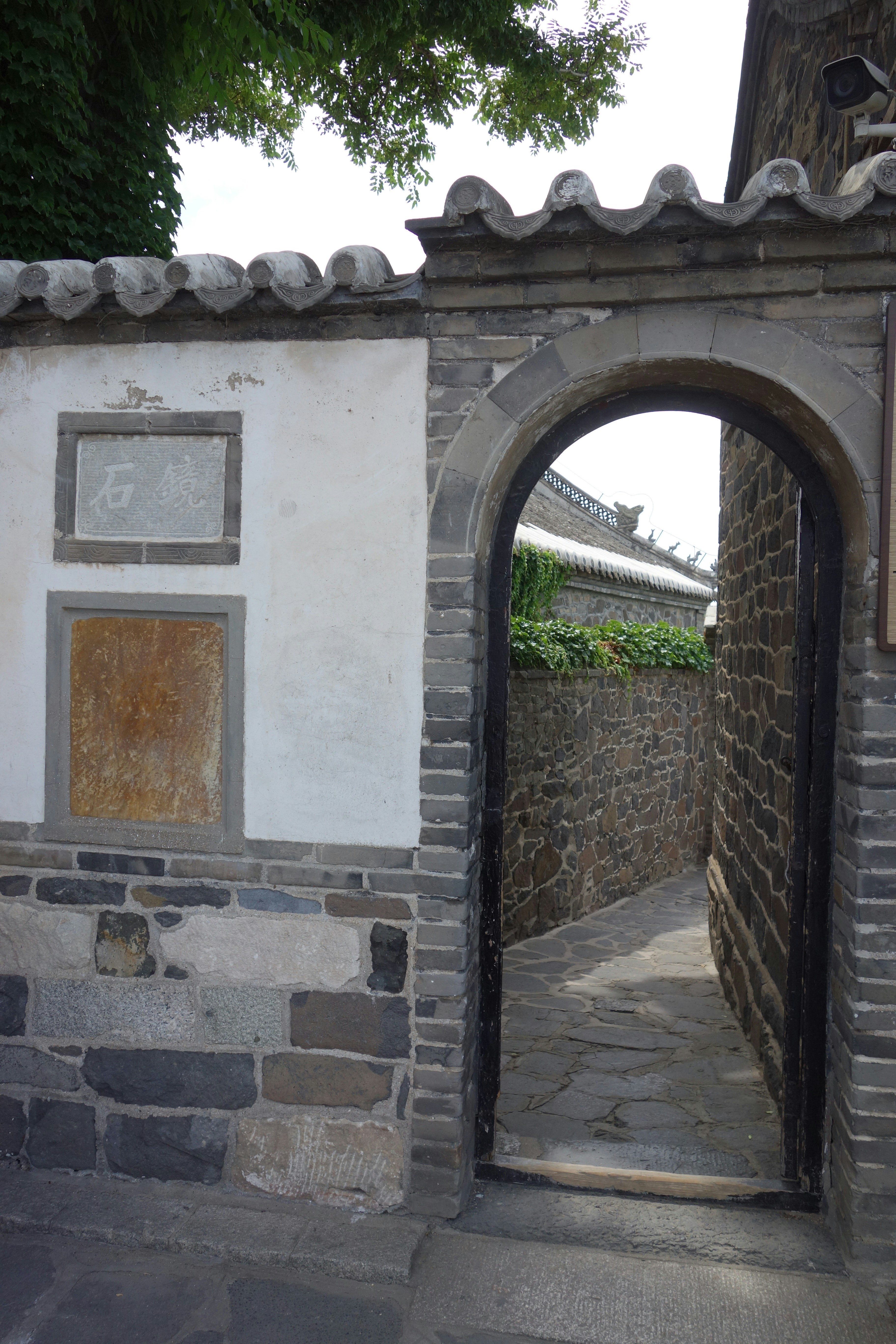 Entrance to the Quiet Courtyard: Archway Framed by Weathered Brick