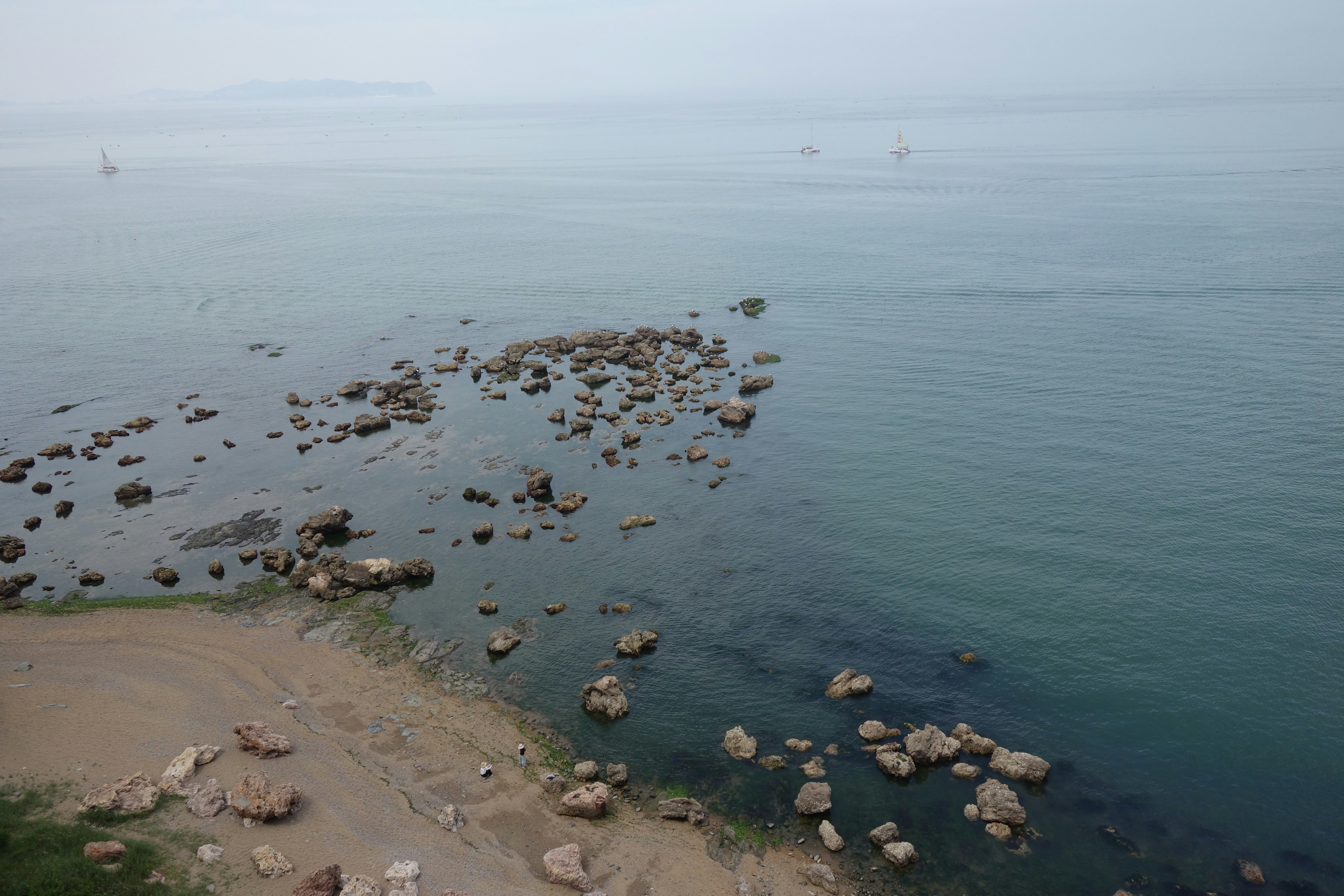 Coastal Outrigger: Stones, Sand, and Sea in Calm Light