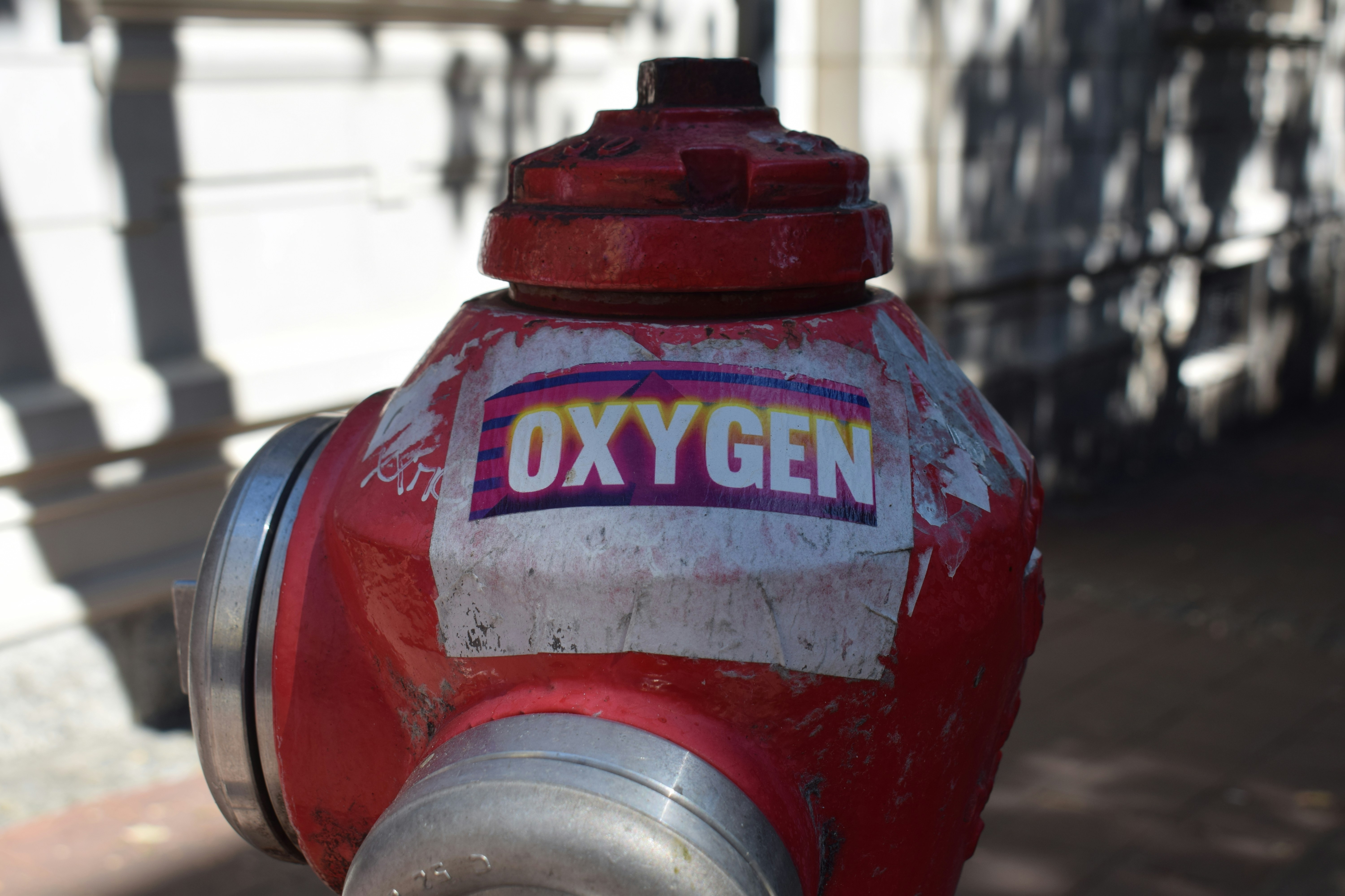 Red Fire Hydrant with Weathered Sticker in Bright Urban Light