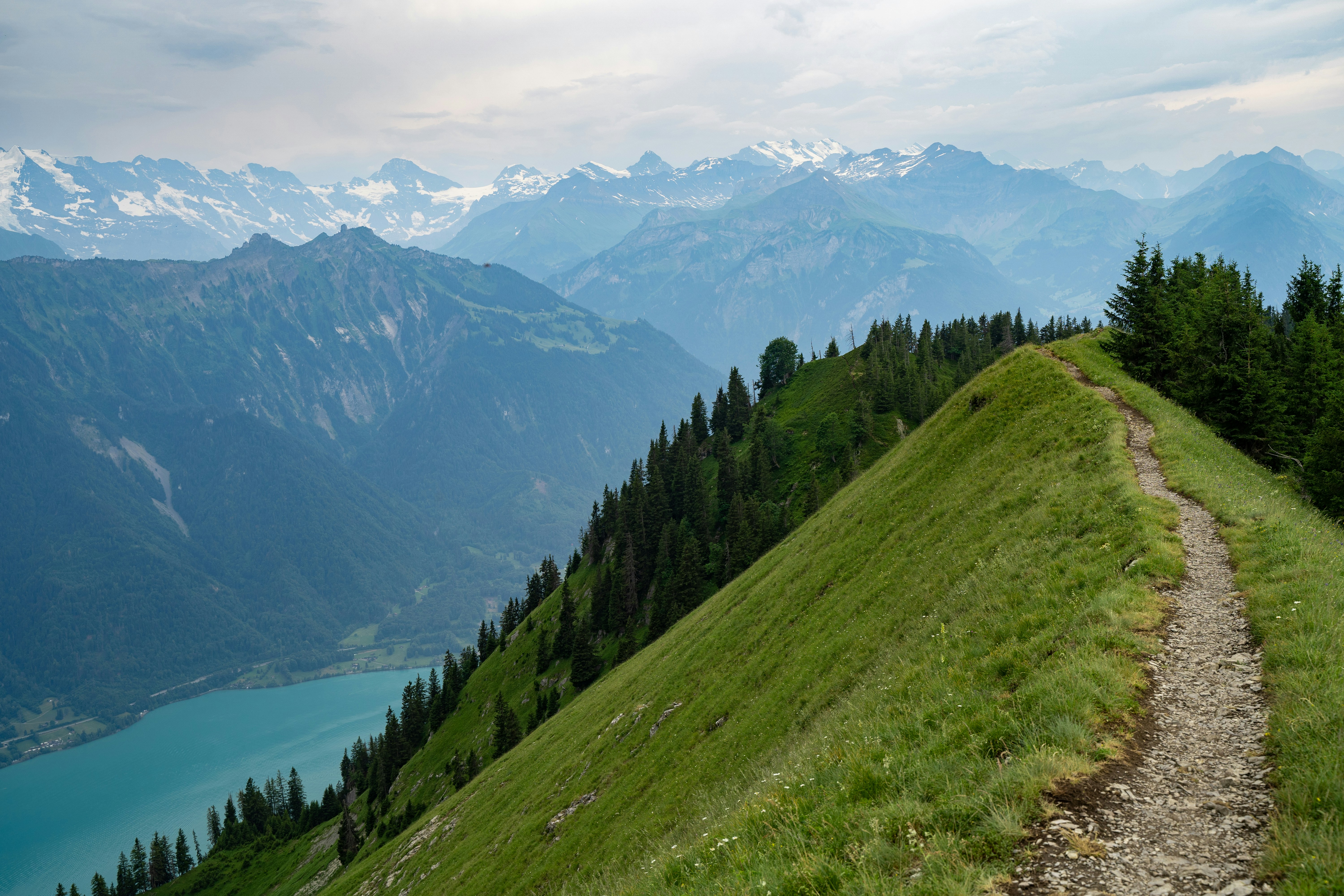 Ridge Route to Misty Peaks Over a Turquoise Lake