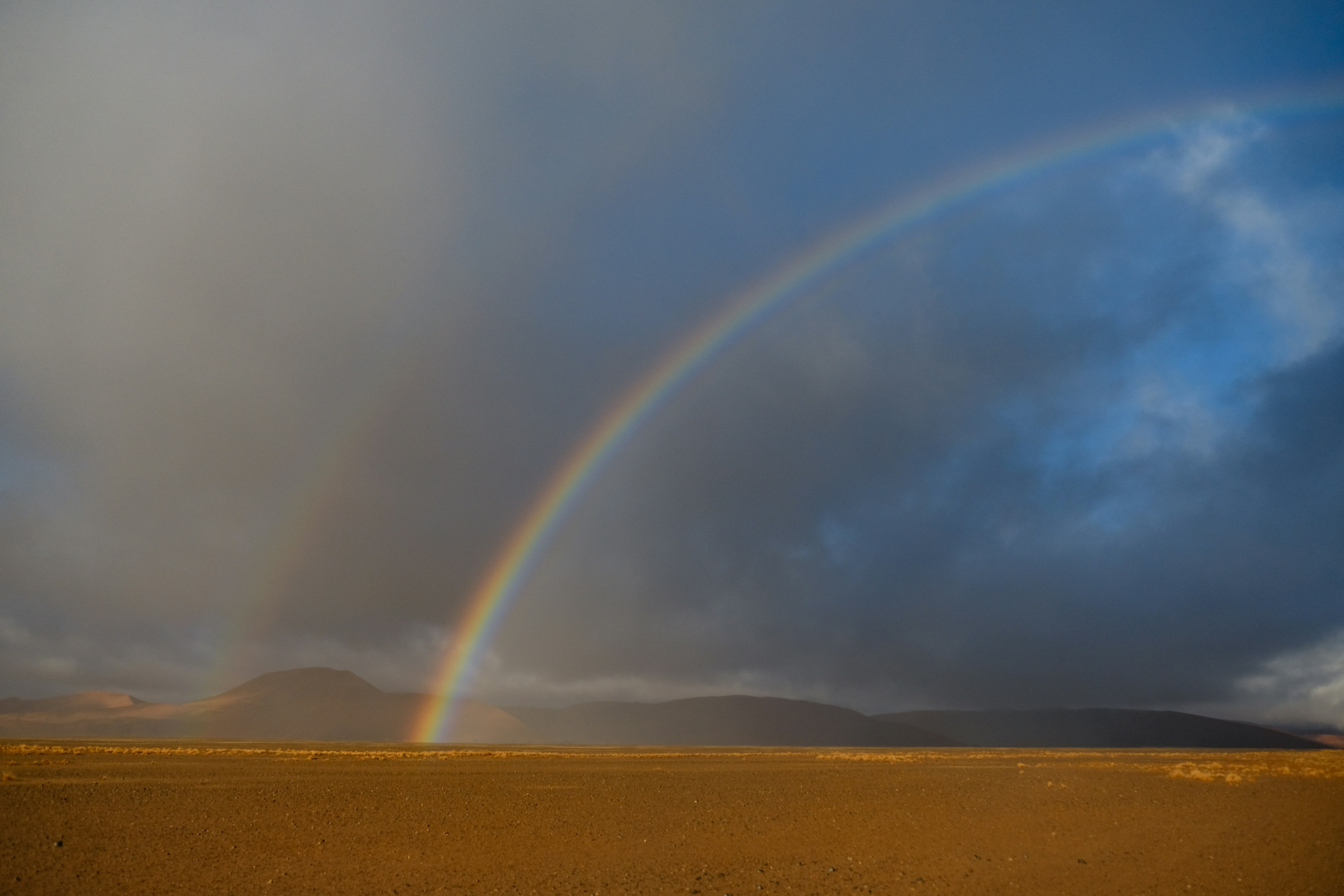 Double Arc over Desert Plains at Dusk