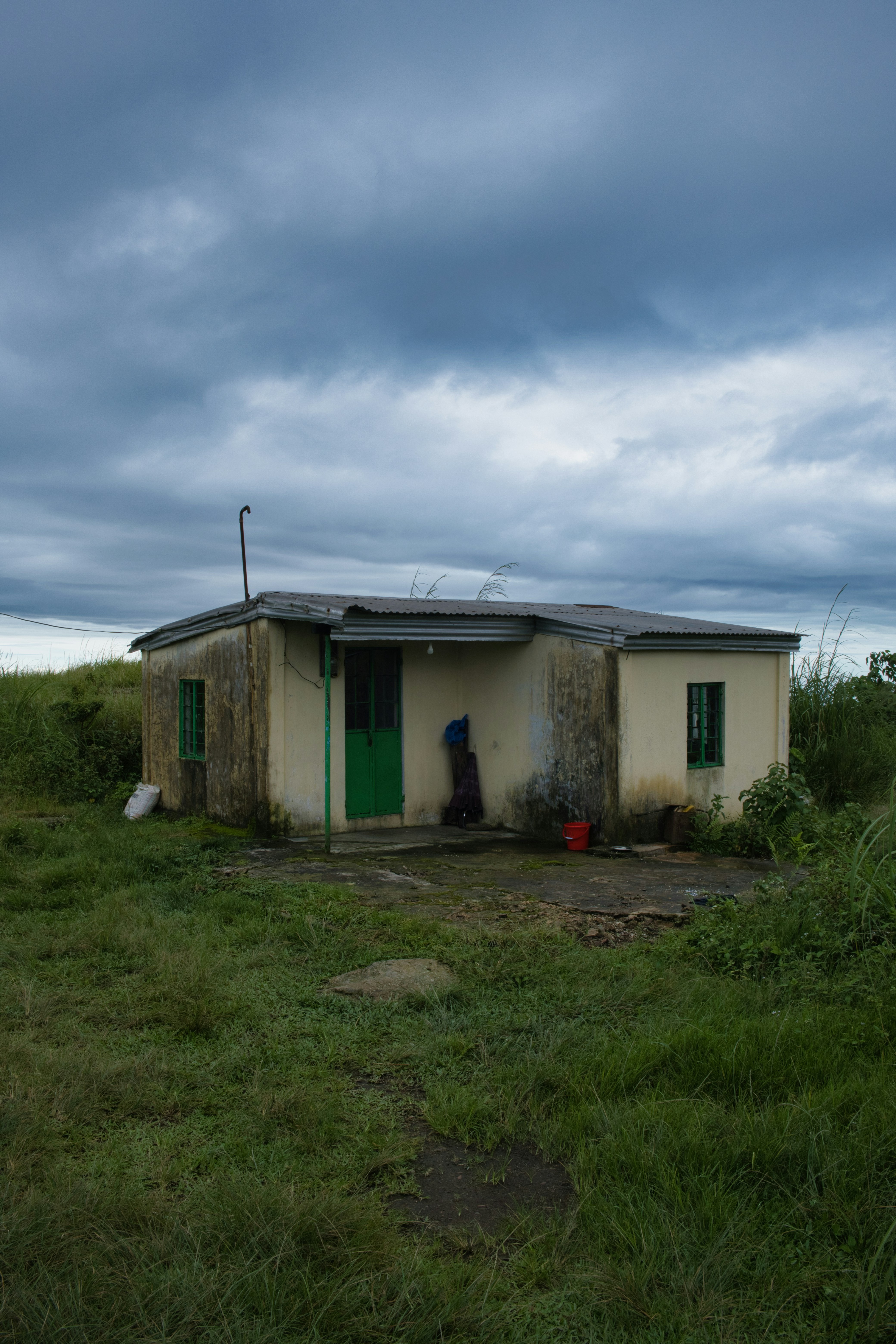 Weathered Refuge: A Small House Amid Skyward Turbulence