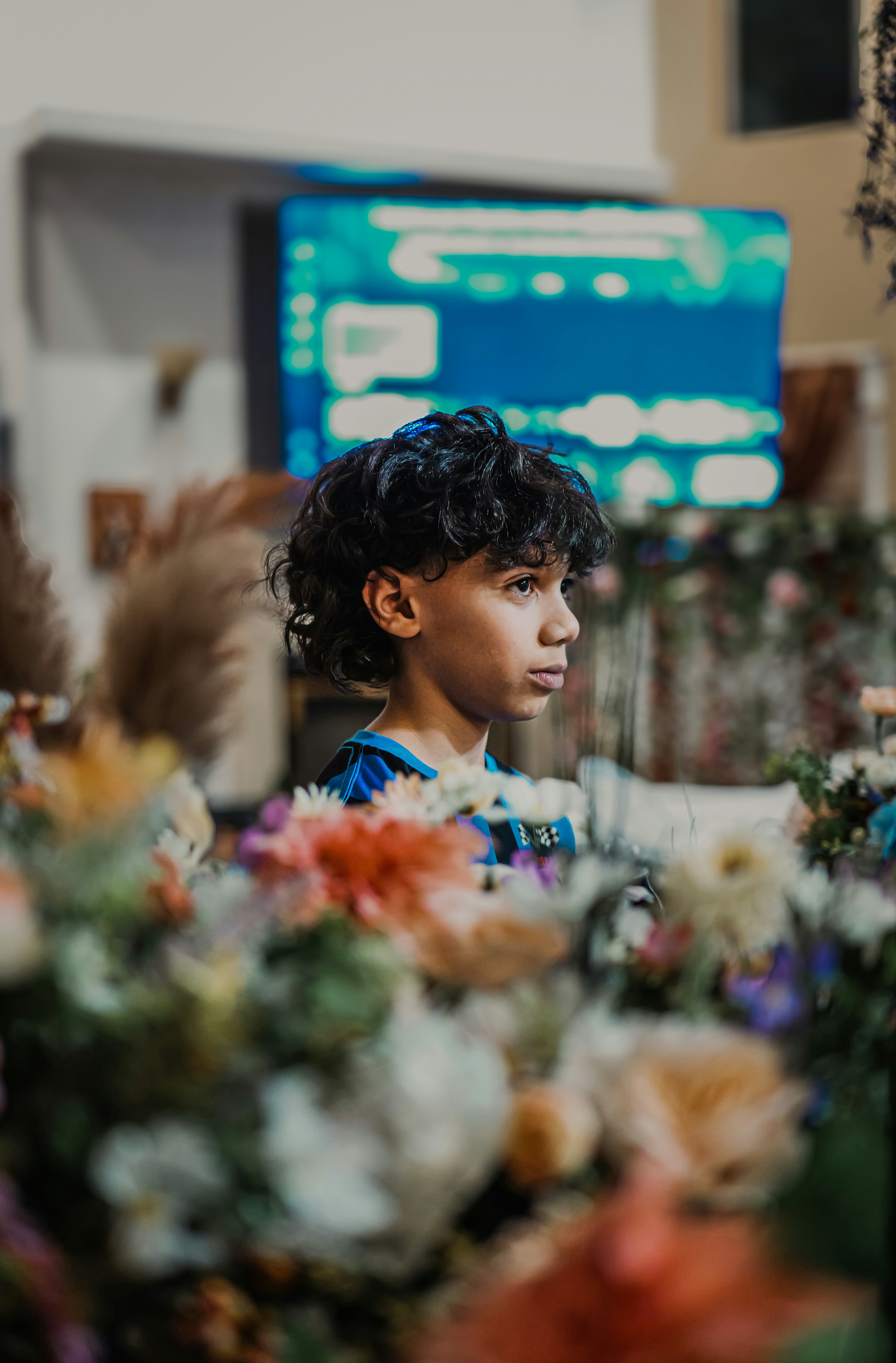 Youthful Gaze Amid Colorful Blooms Under a Neon Screen