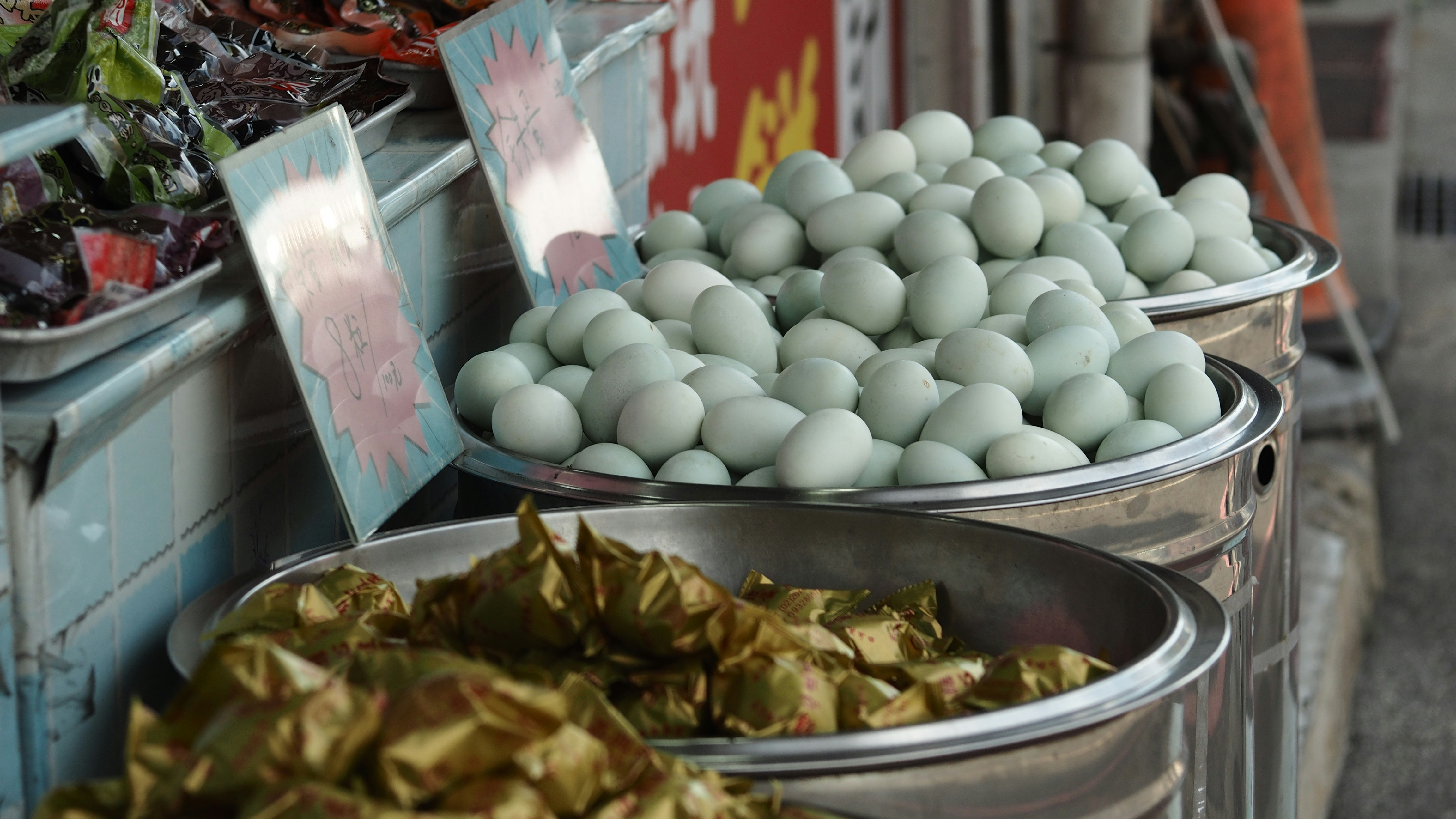 Market Carton of Pale Green Eggs on Shiny Metal Buckets