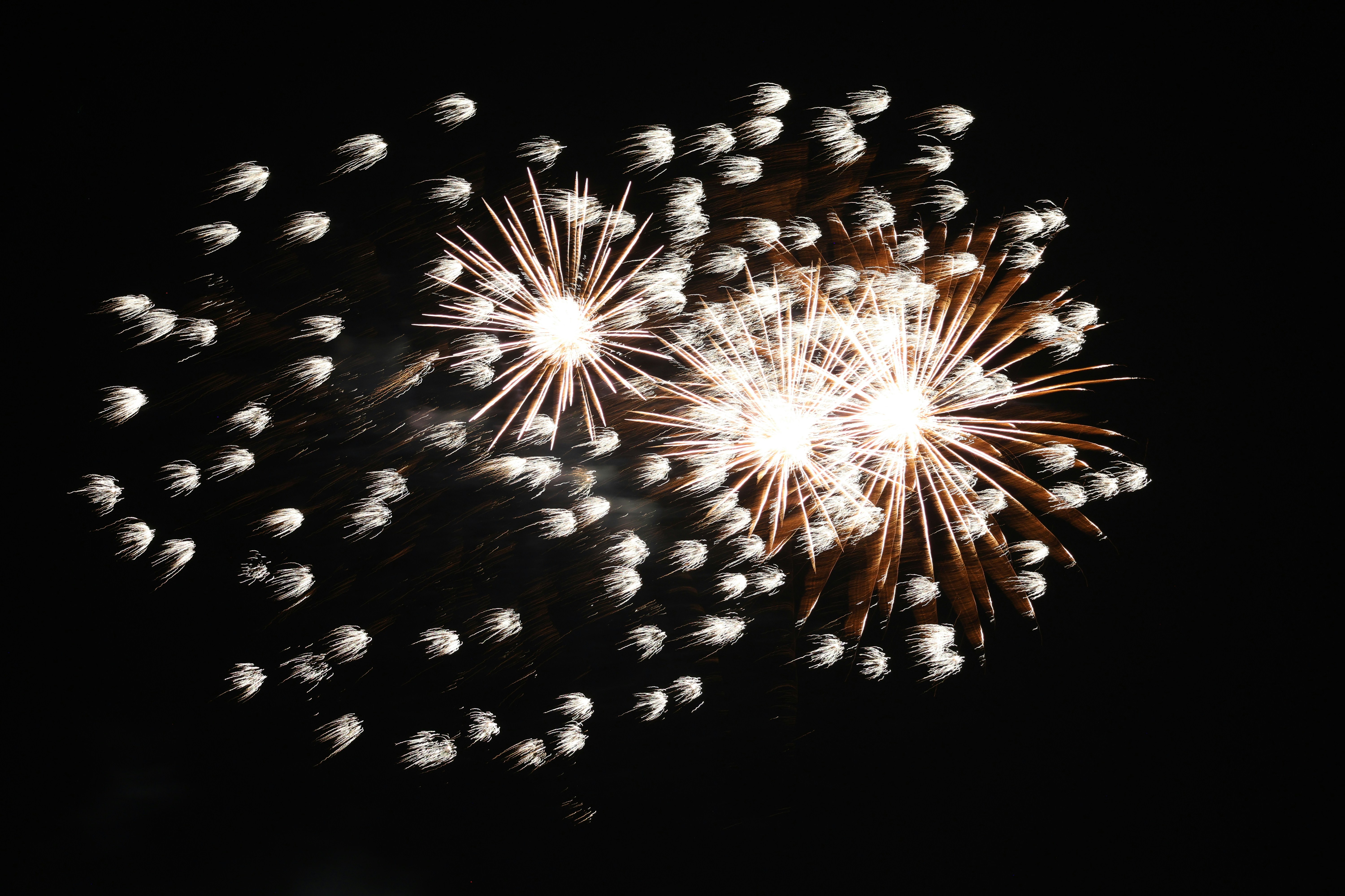 Cascades of Light: Dual Fireworks Burst Against Night Sky