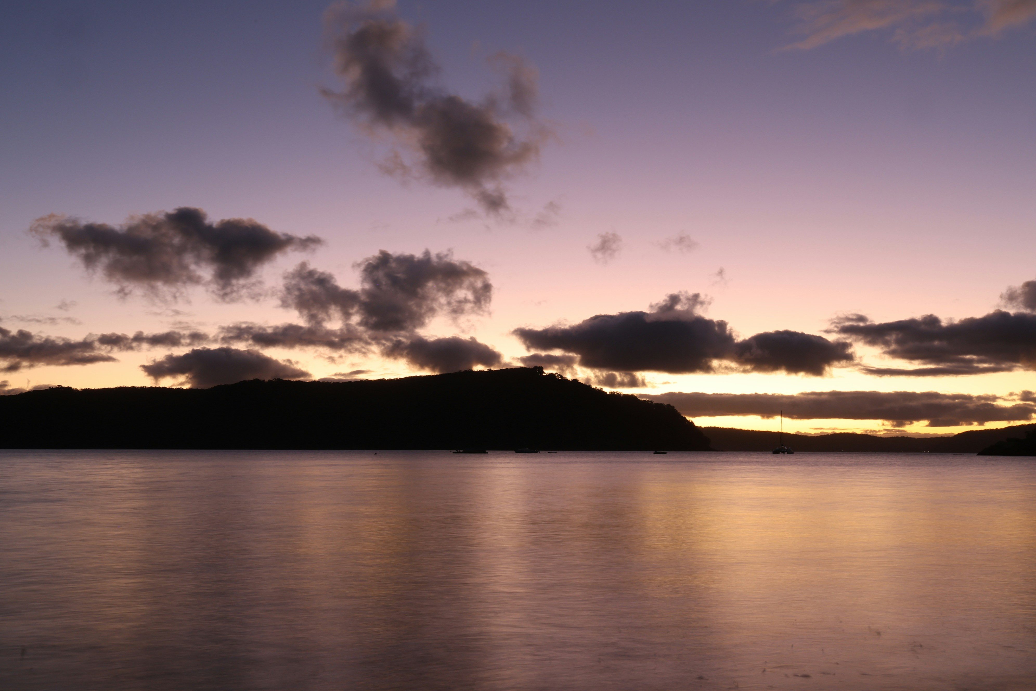Horizon at Twilight: Silhouette Over Calm Waters