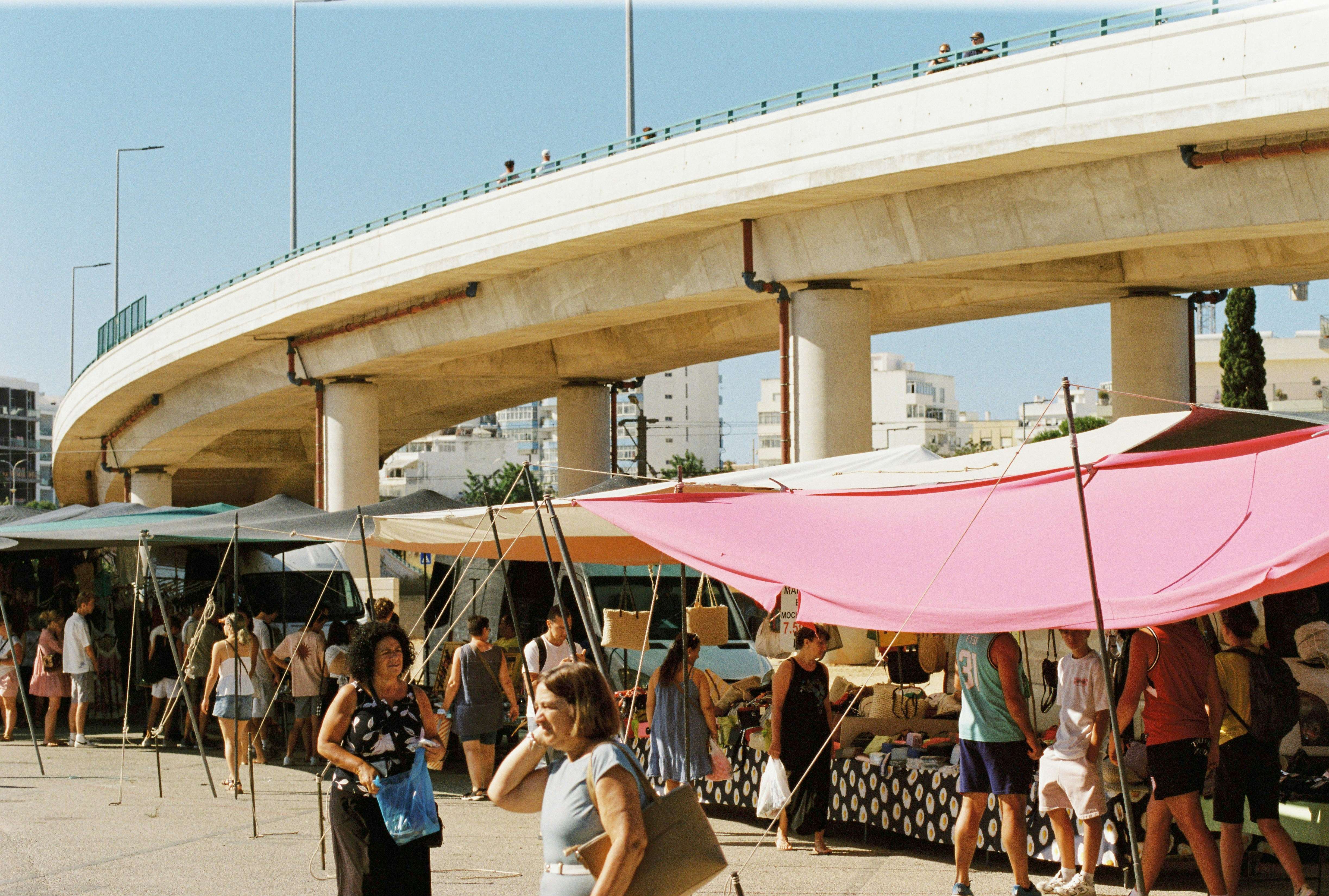 Under the Canopy of a Busy Market: Sunlit Tents and a Moving Crowd
