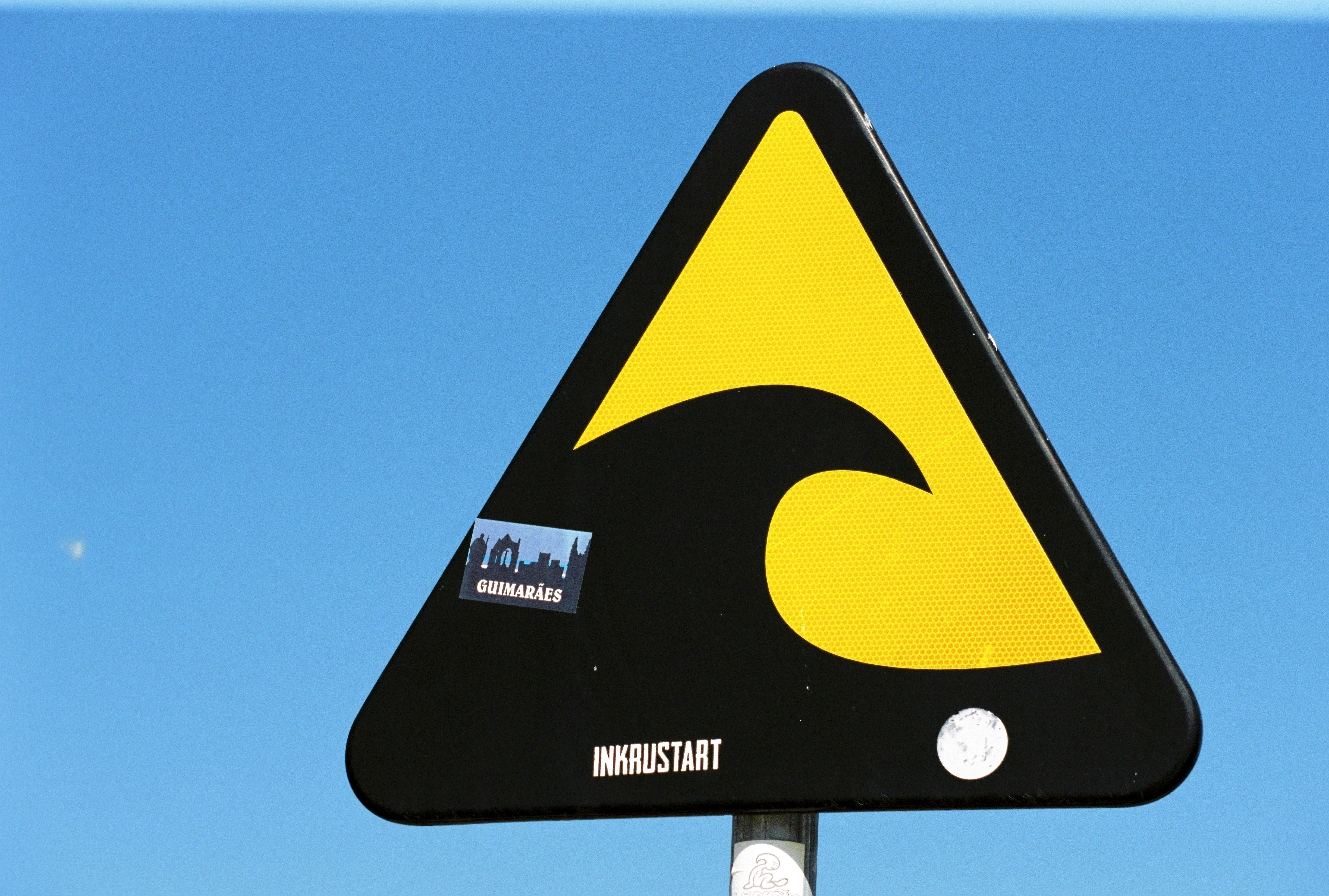 Bright Yellow Caution: A Lone Warning Sign against a Clear Blue Sky