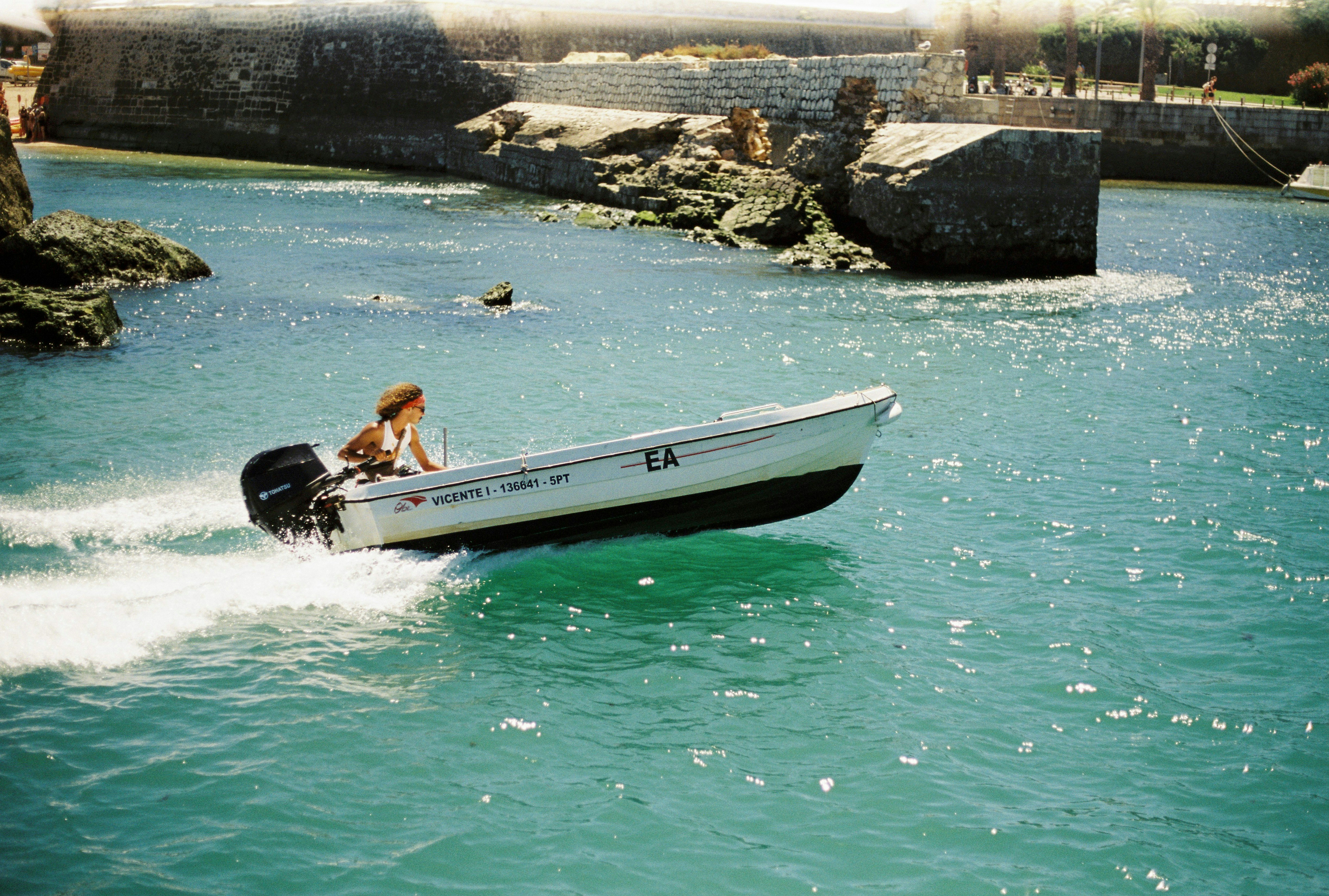 Rapid white-boat dash across turquoise harbor