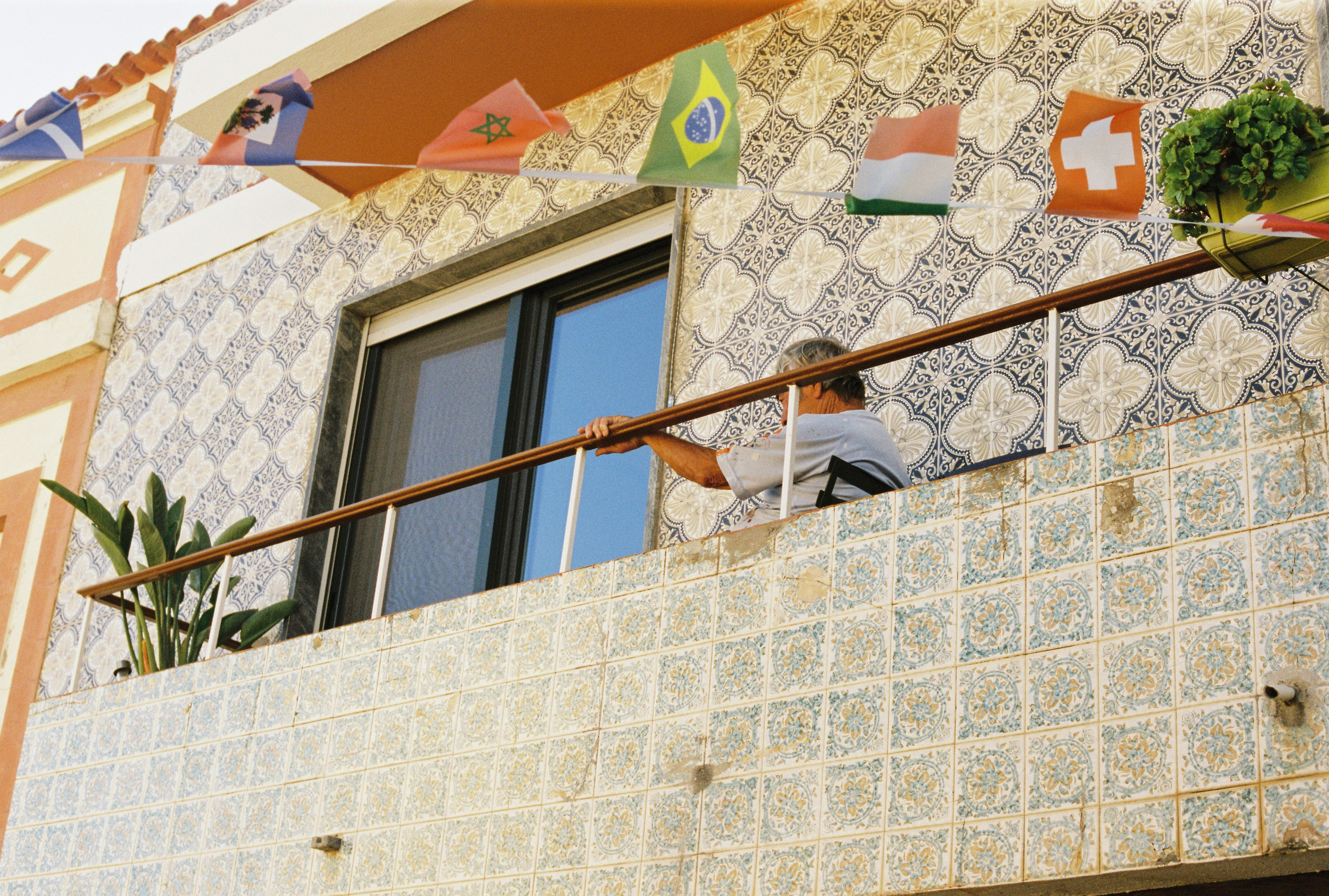 Flags on the Balcony Rail: A Sunlit Moment of Shared Space