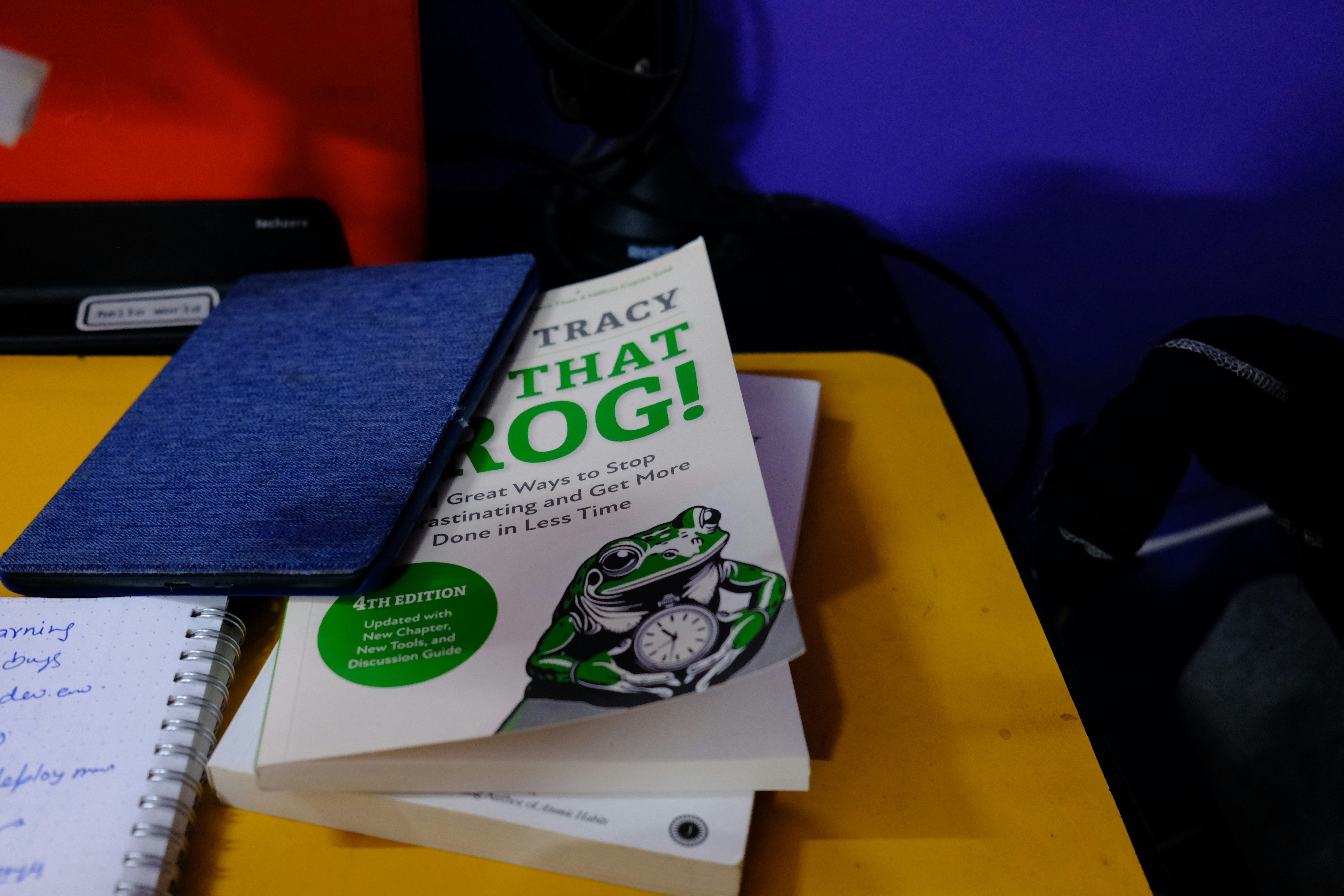 Desk clutter, bold colors, and a green-accented book centerpiece