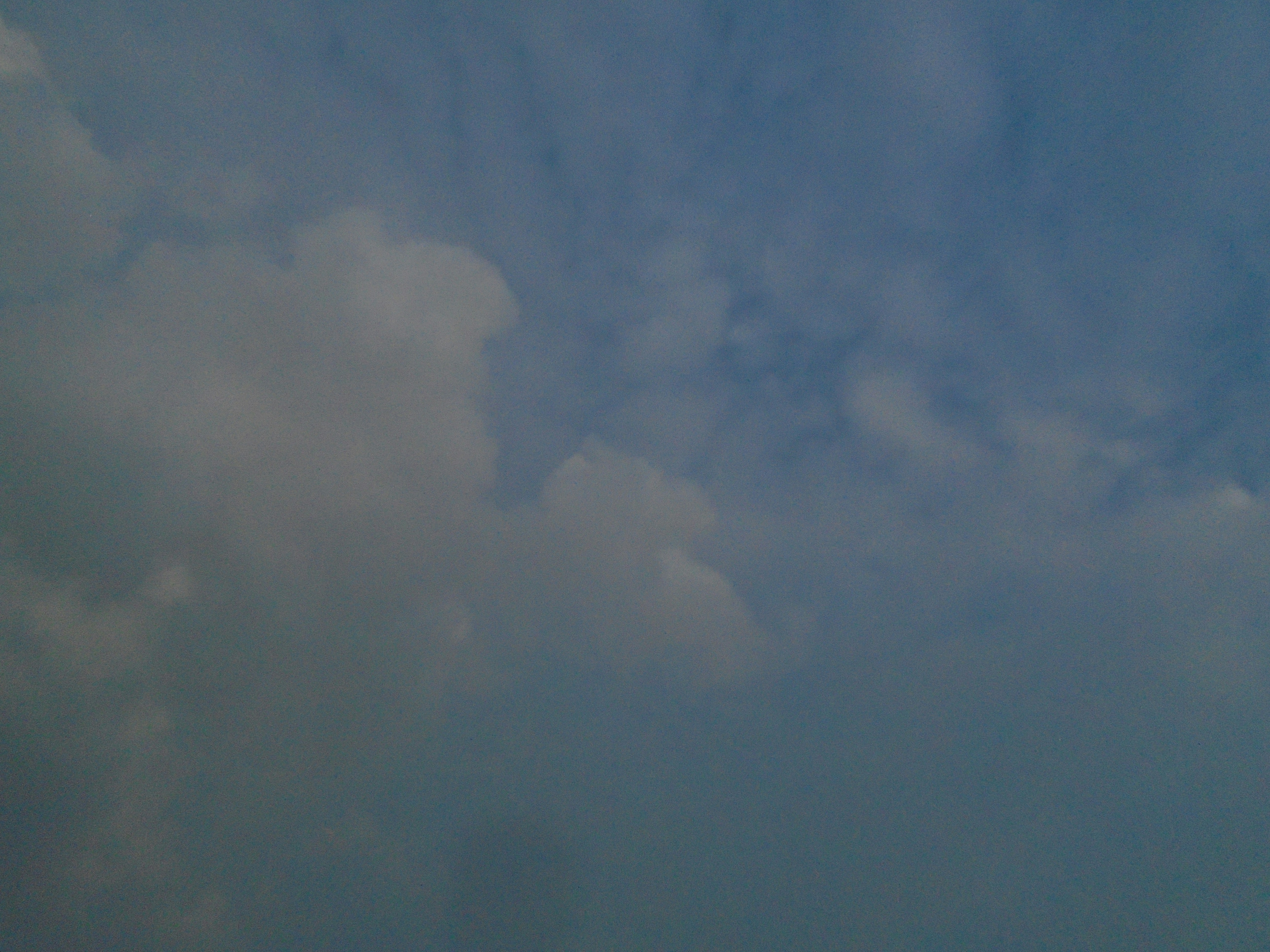 Soft clouds drift across a calm blue sky, with subtle tonal variations and a peaceful atmosphere. A minimal sky scene suitable for a calm background or contemplative mood. 