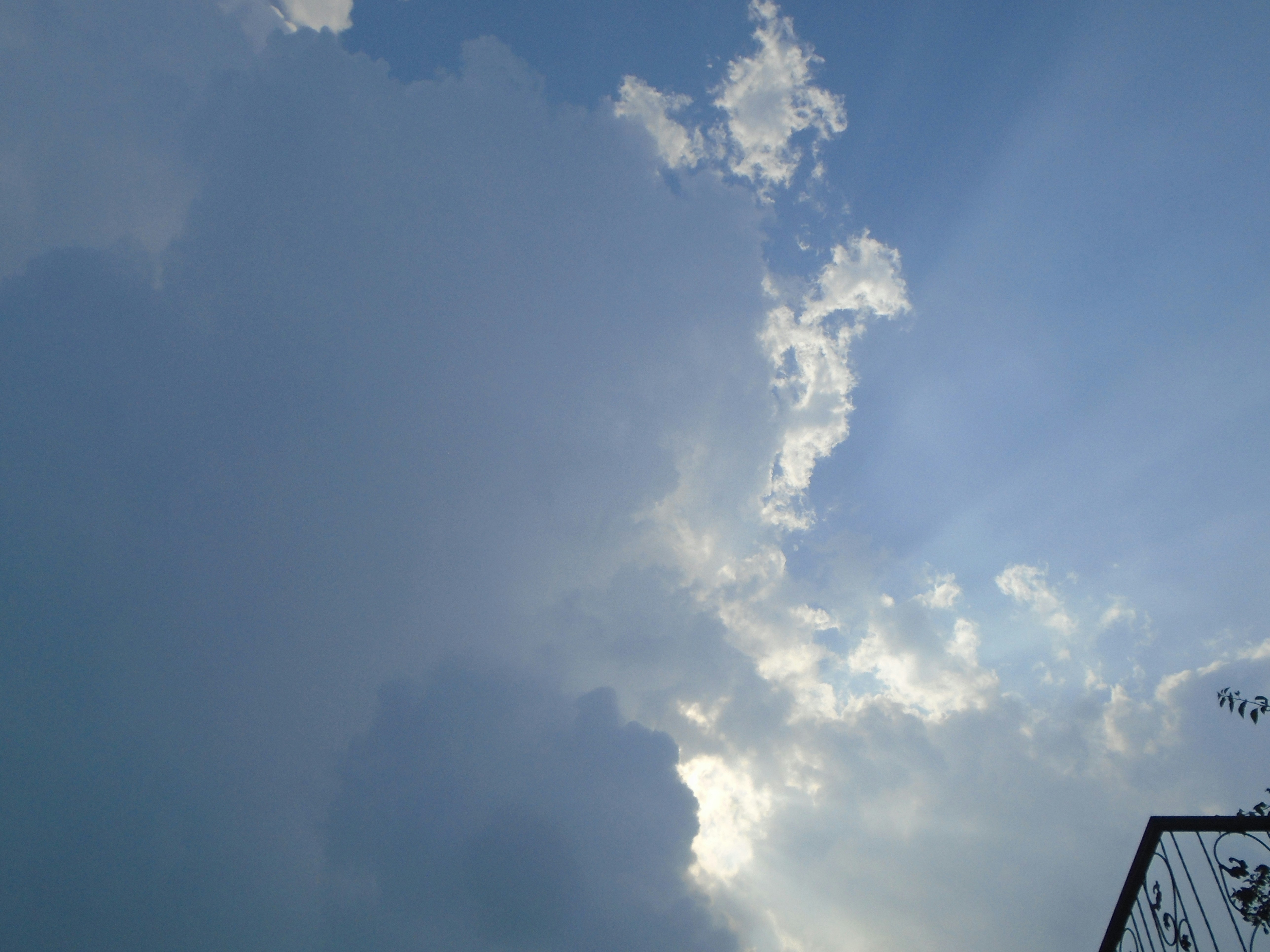 Bright Sky Break: Sunlit Cloud Edge Beyond a Corner Silhouette