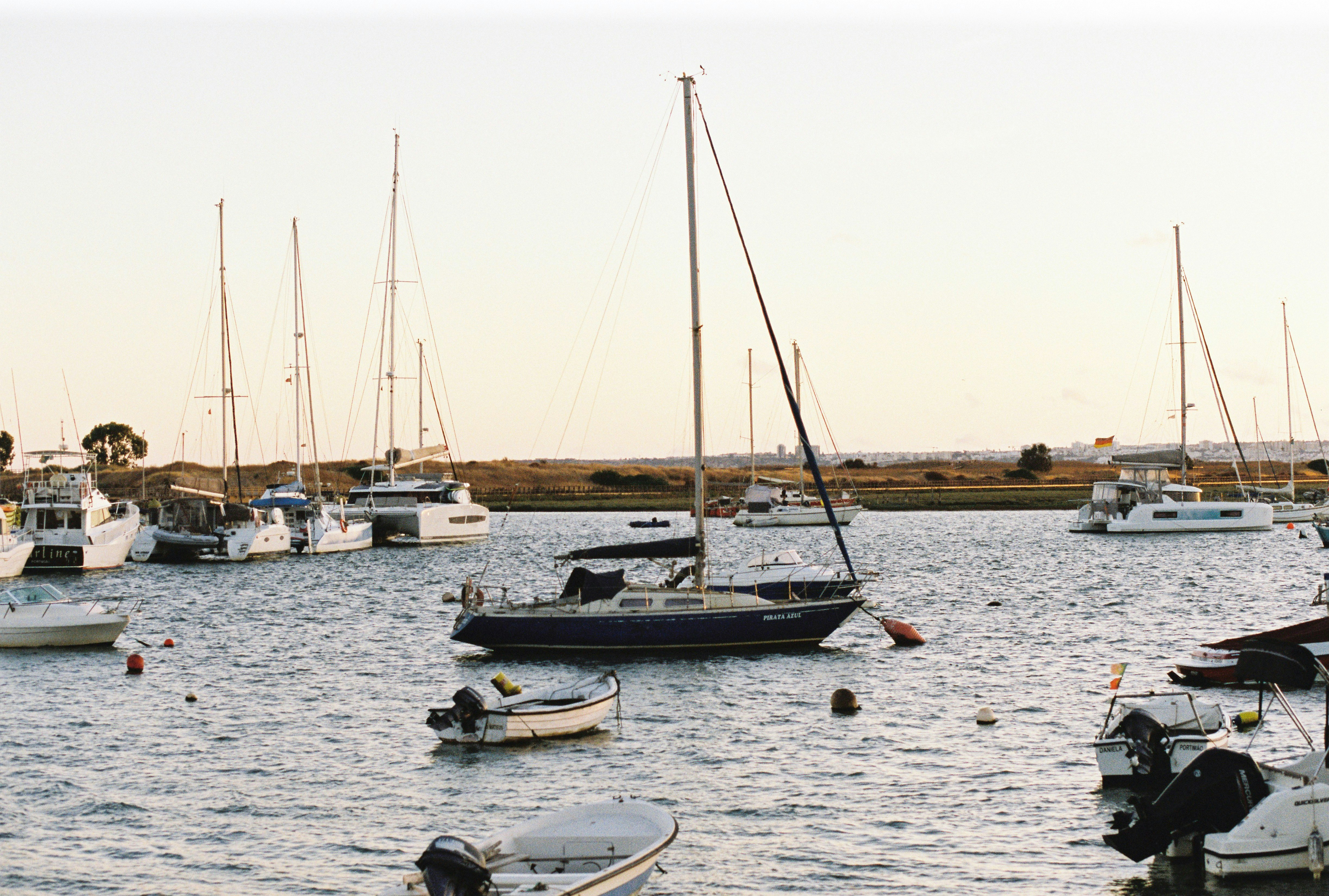 Quiet harbor at golden hour: sailboats resting on calm waters