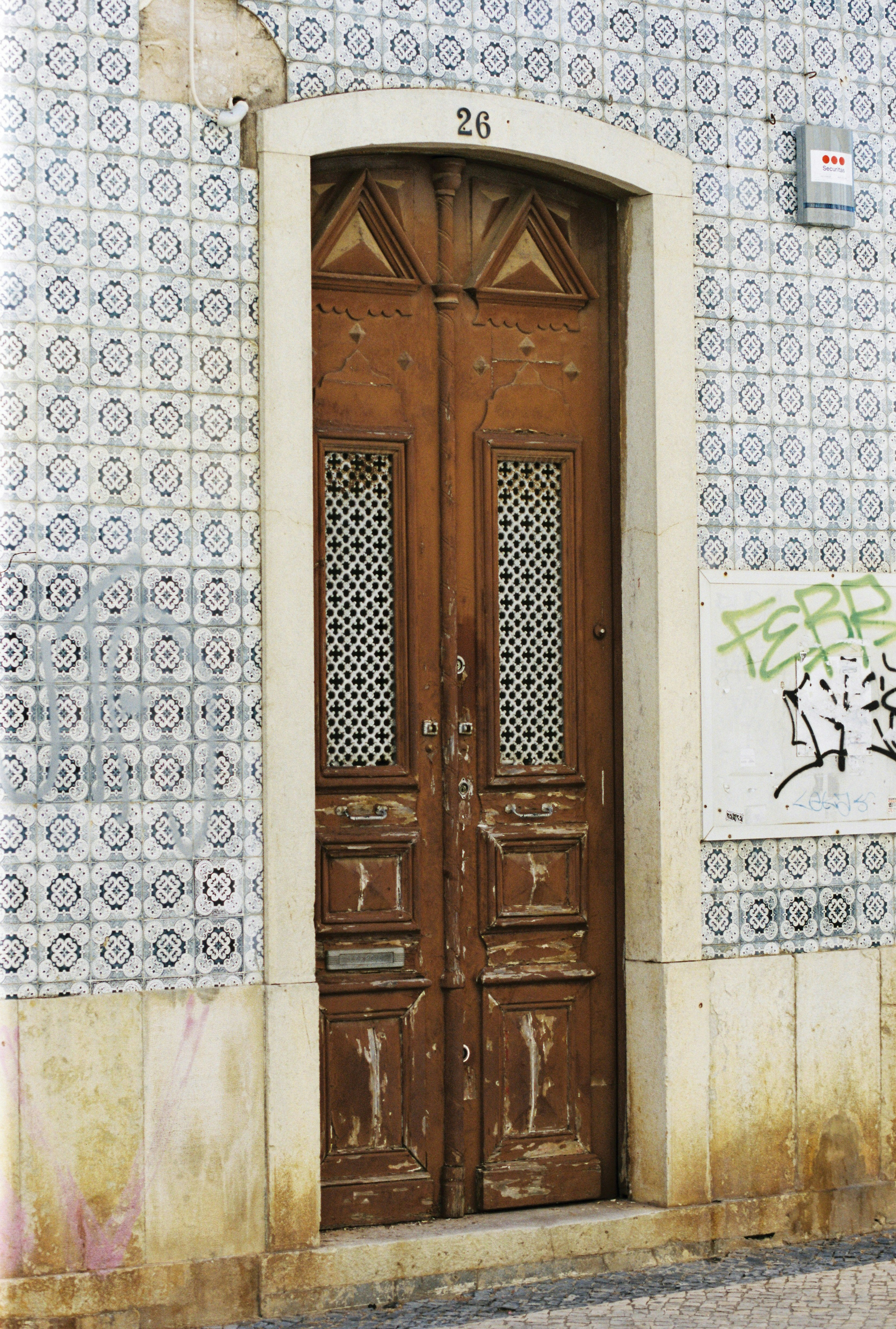 Weathered Doorway on Tile-Arched Facade