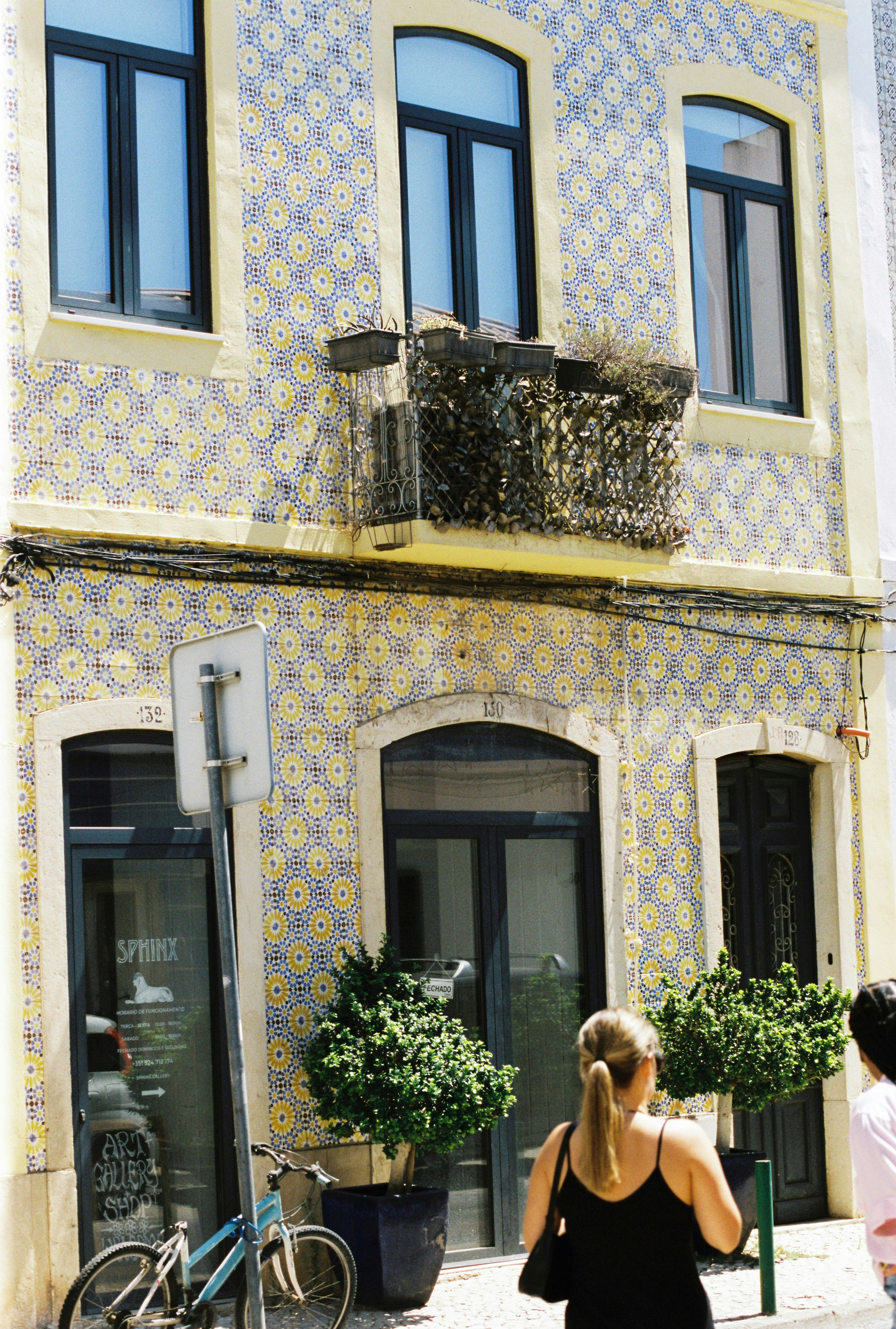 Tilework and Terrace: A Sunlit Facade of Blue and Yellow