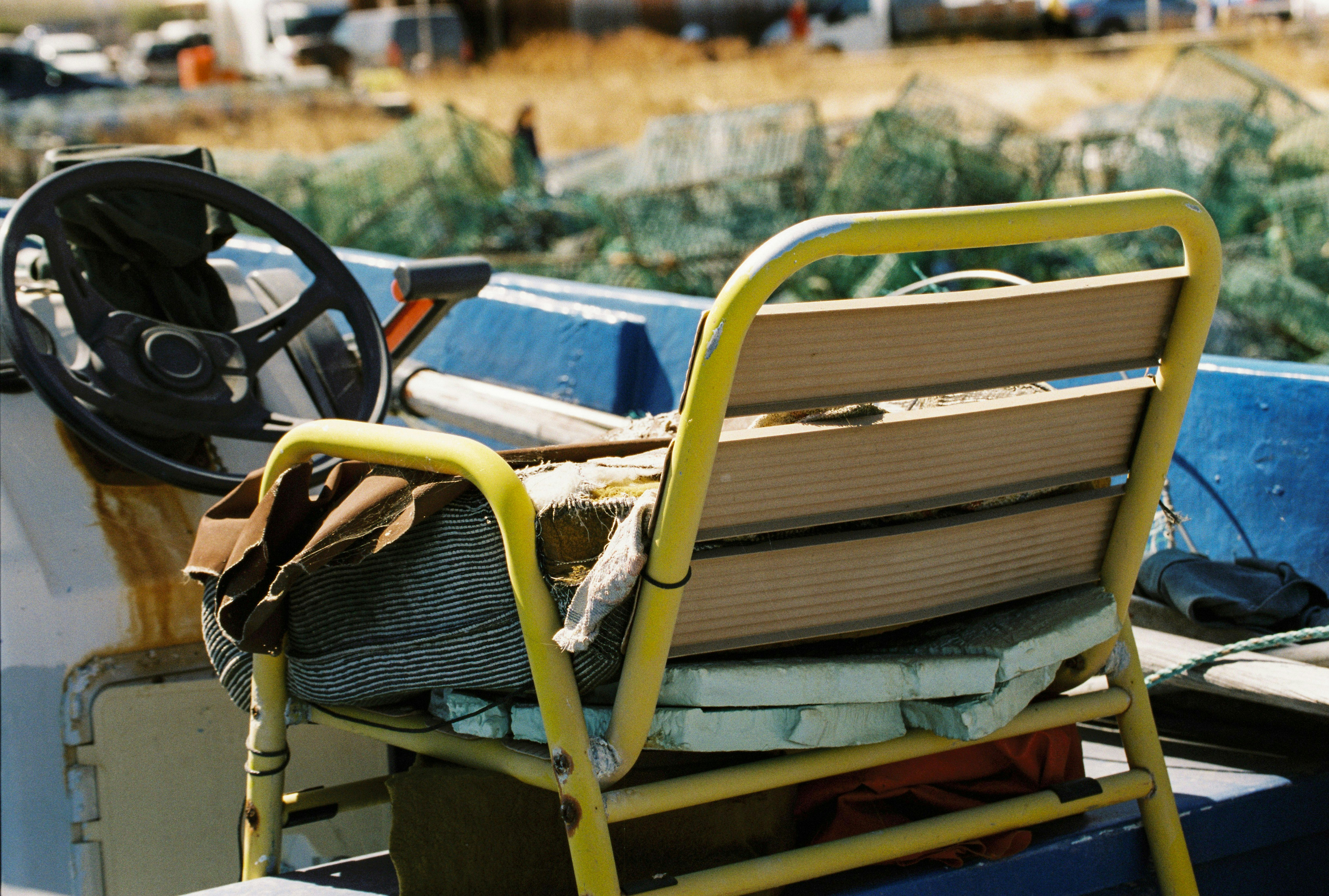 Sunlit Boat Seat: A Weathered Crew’s Rest on a Quiet Dock