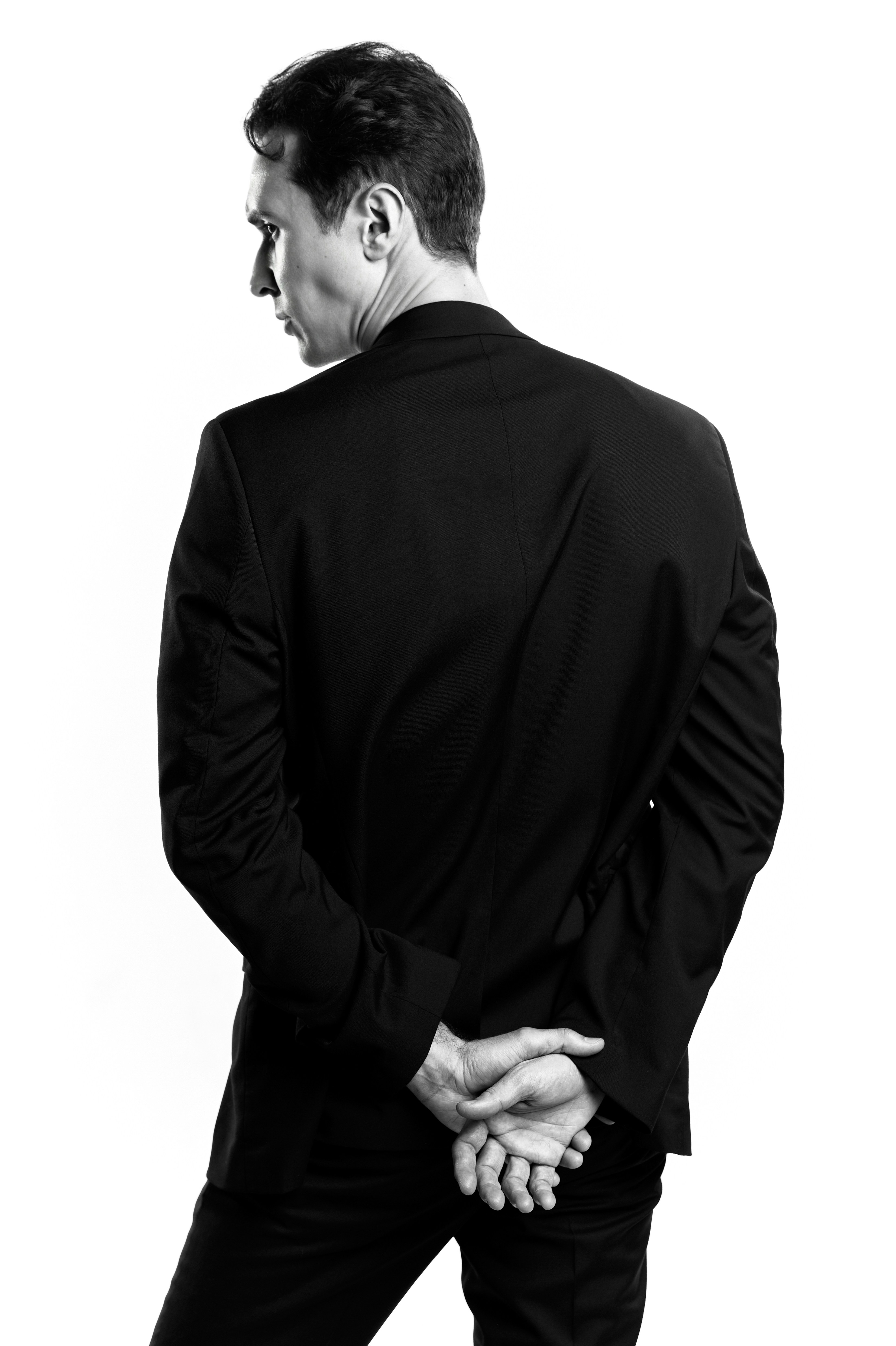 Back-Quarter Portrait in Black: A Sleek Silhouette with Hands Interlocked