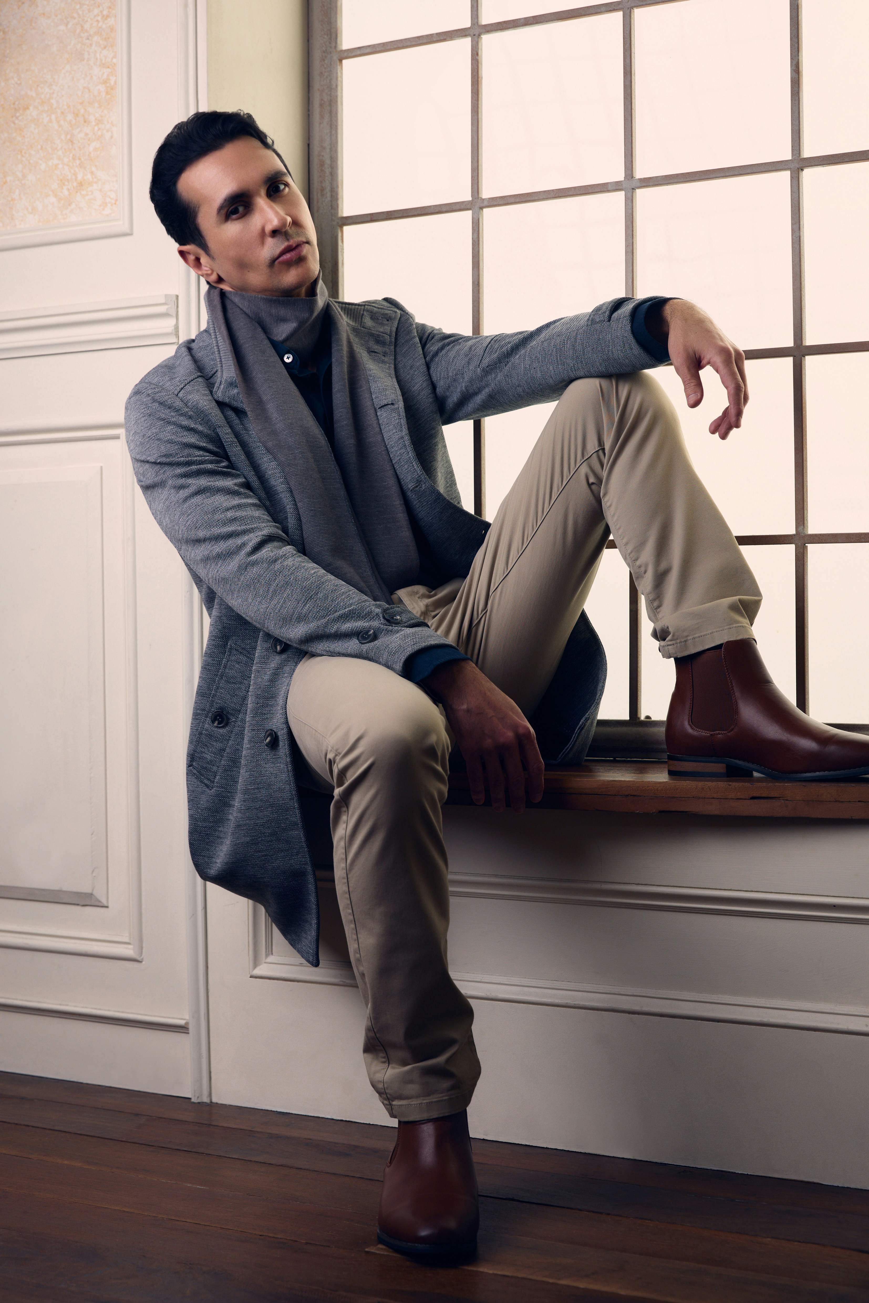 Sleek confidence: a stylish gaze by the studio window