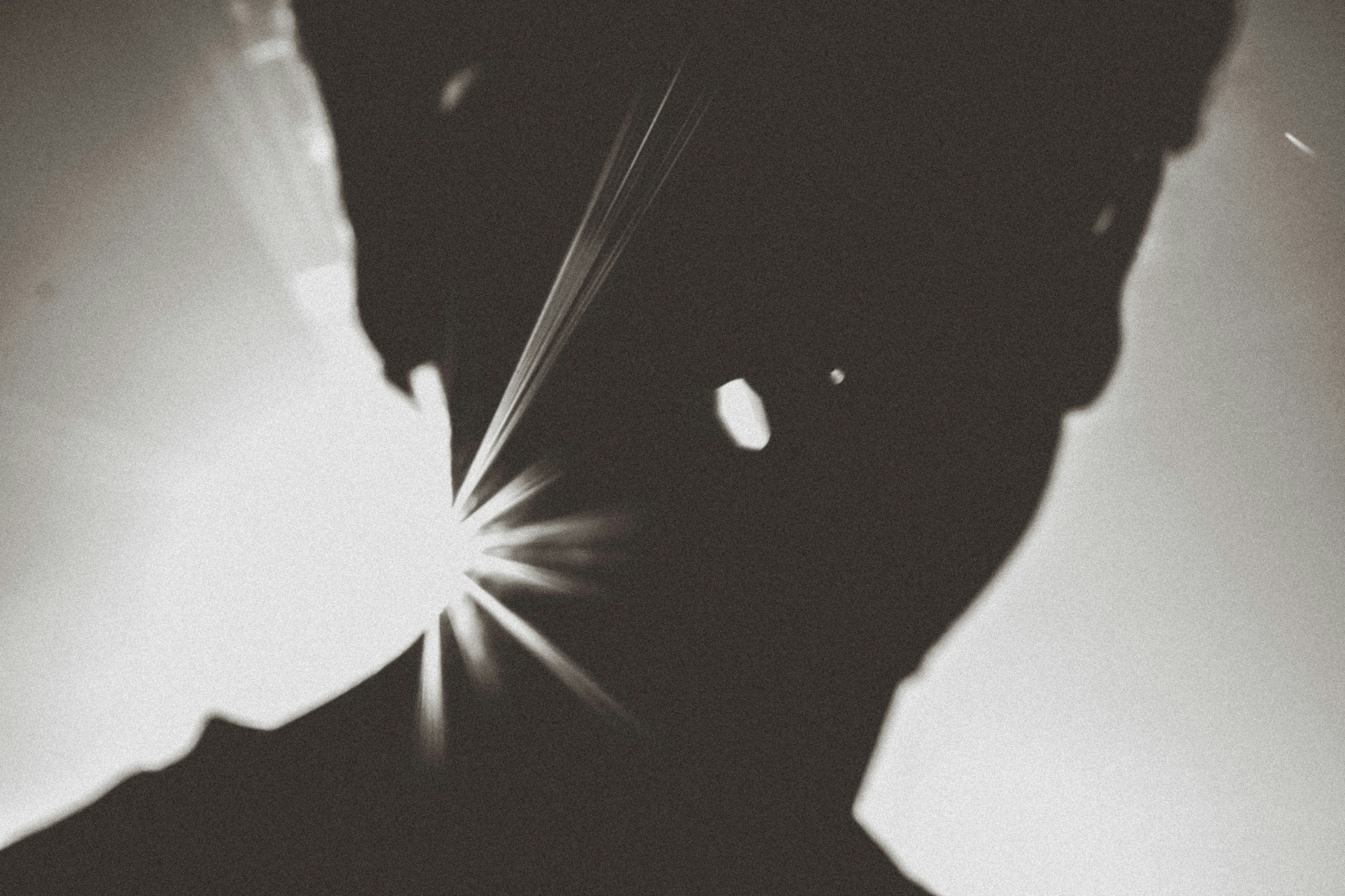 Light Fractures: A Shadowed Silhouette with a Sunburst