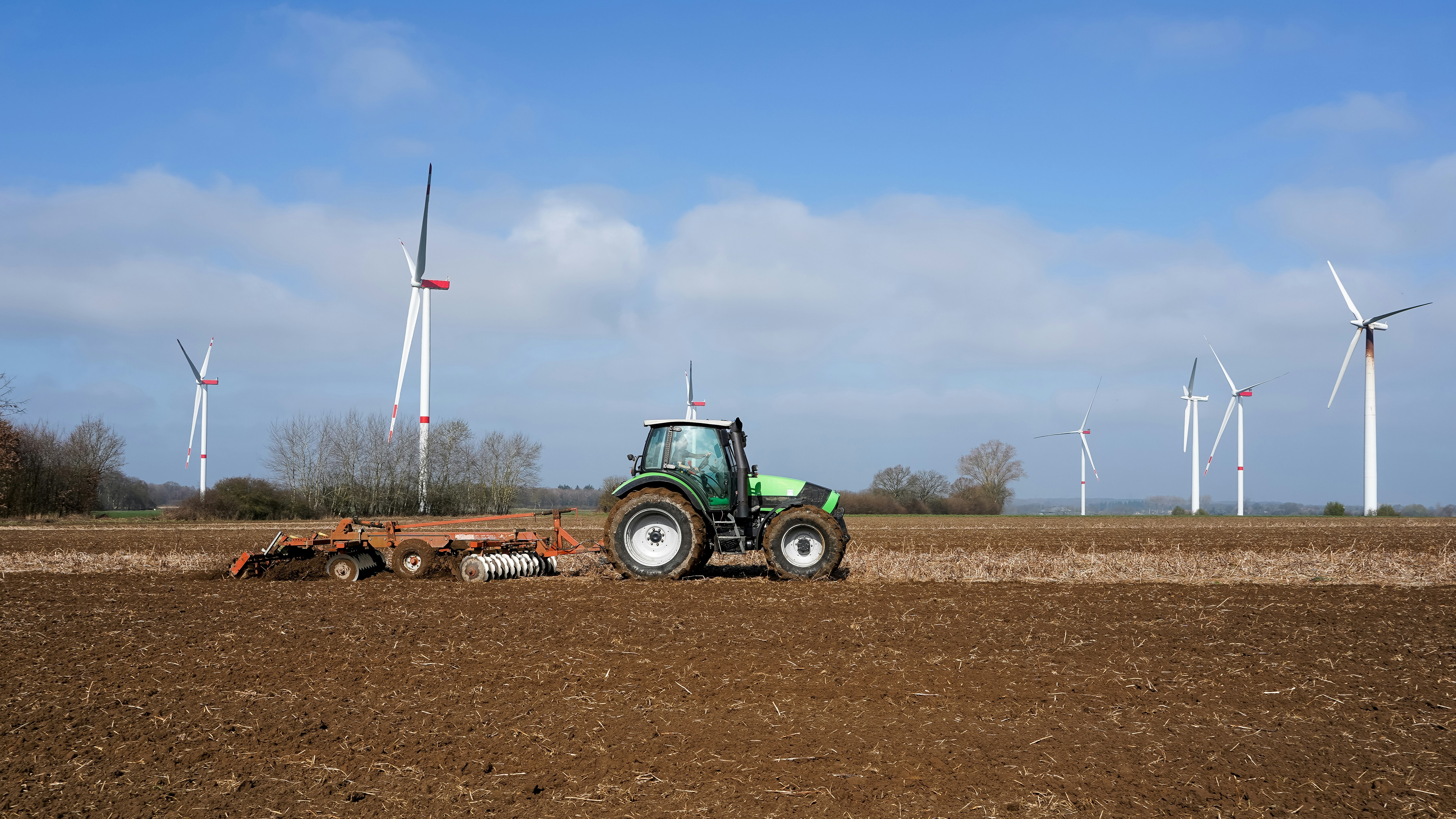 Harvesting Light: Tractors and Turbines in a Wind-Swept Field