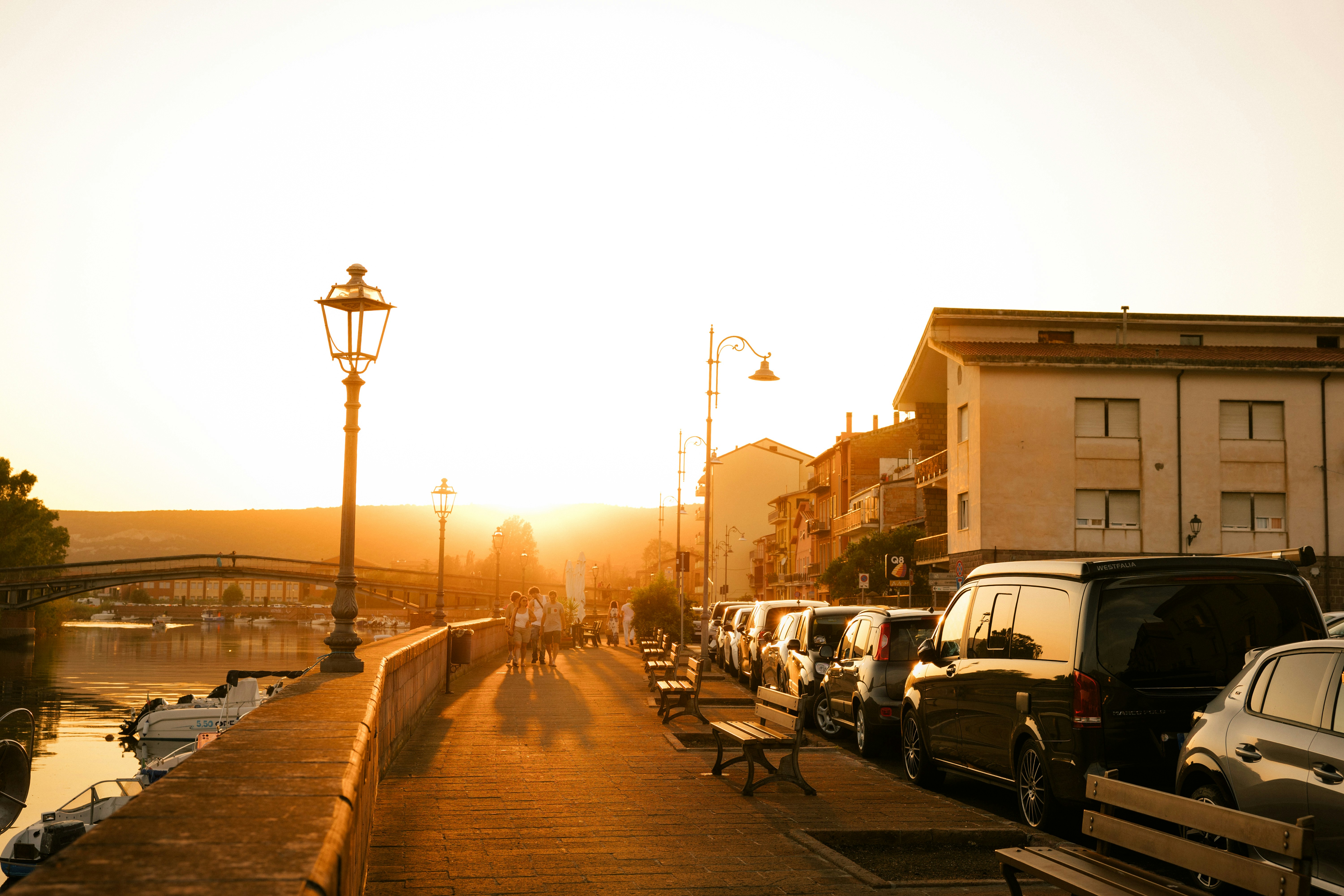 Golden Hour Promenade: Boats, Benches, and Street Lamps