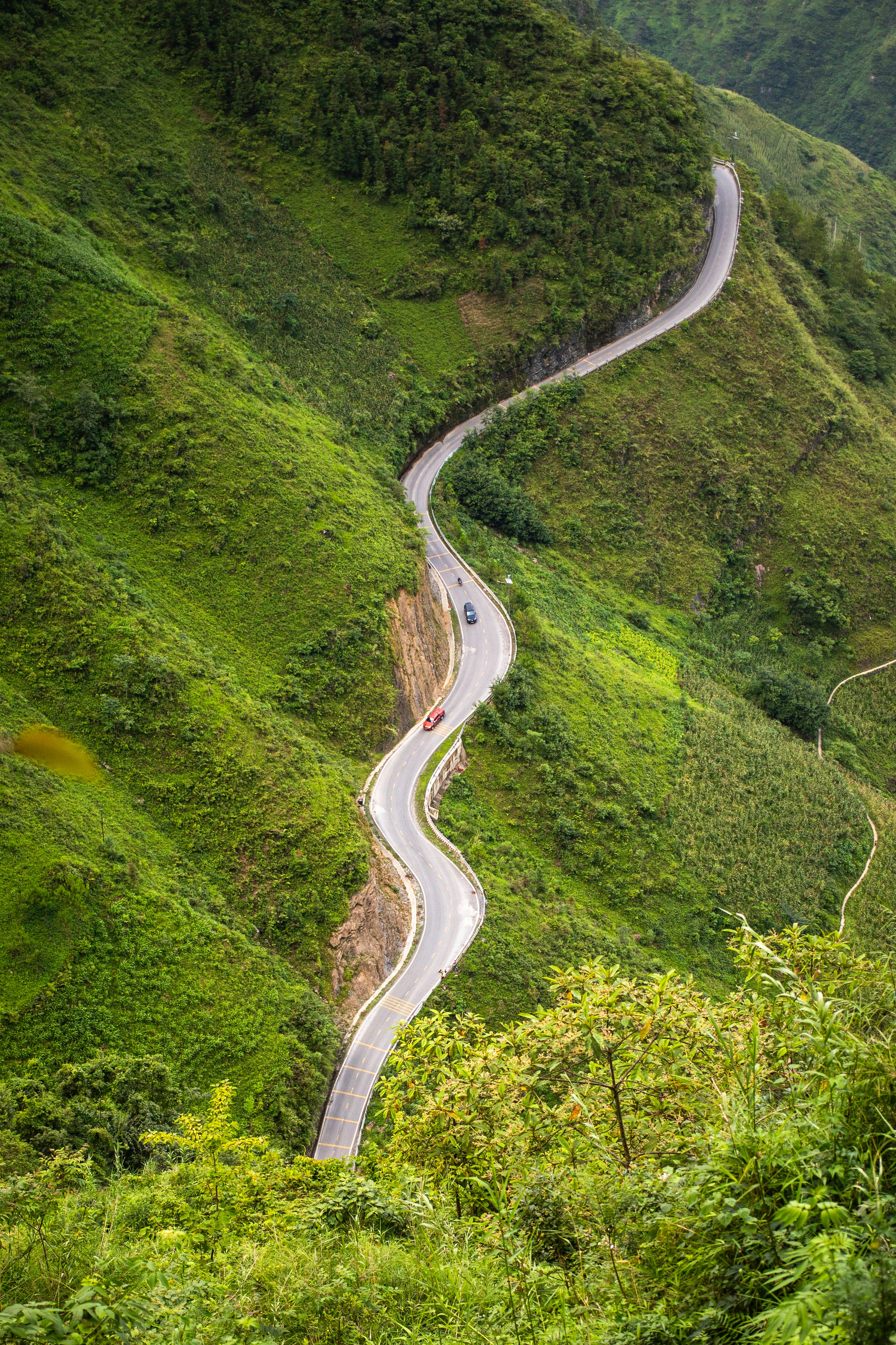 Switchbacks Through Emerald Mist: A Drone’s Descent Along a Winding Mountain Road