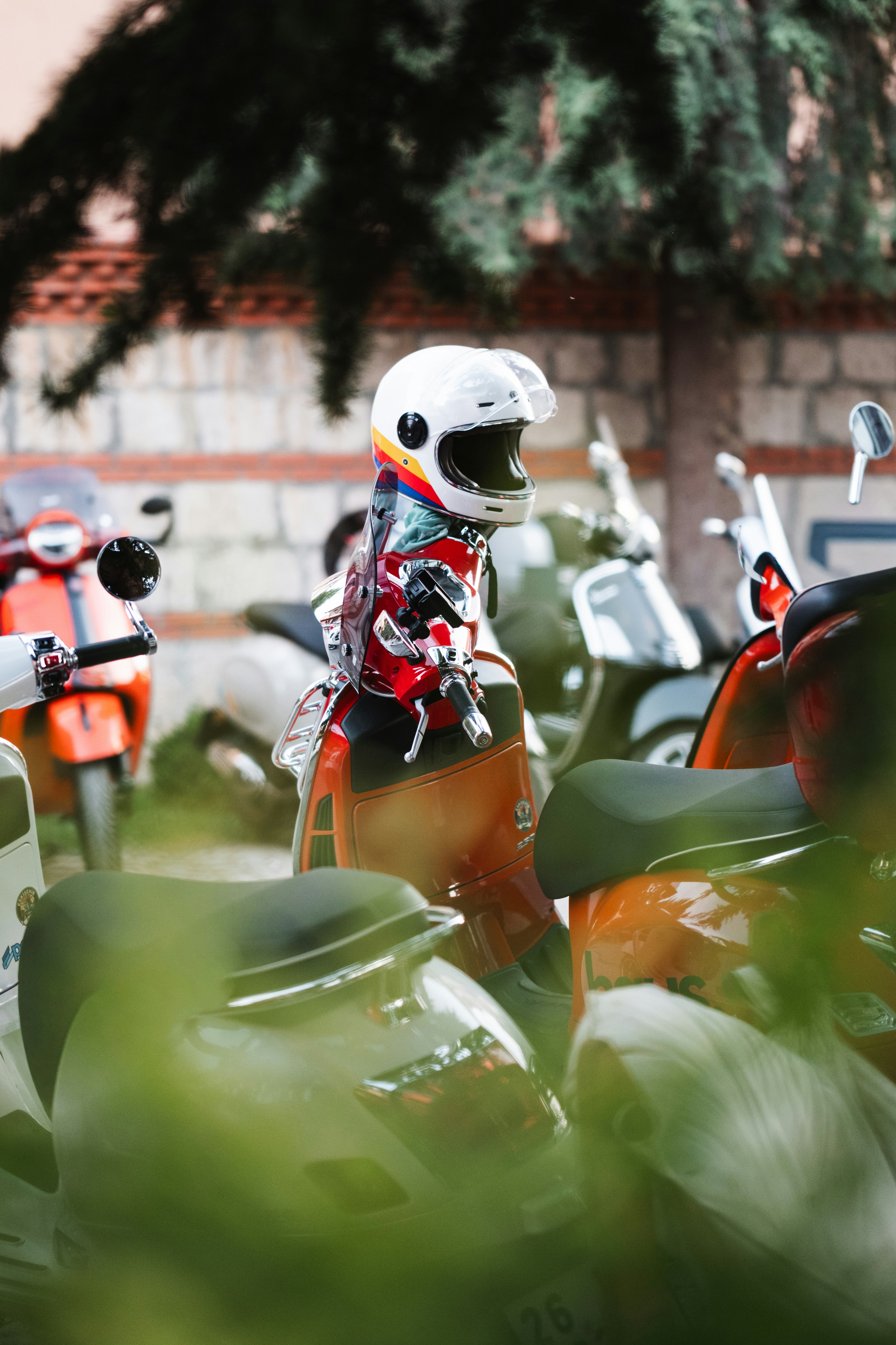 Helmeted Focus: A Quiet Row of Scooters in the Shade